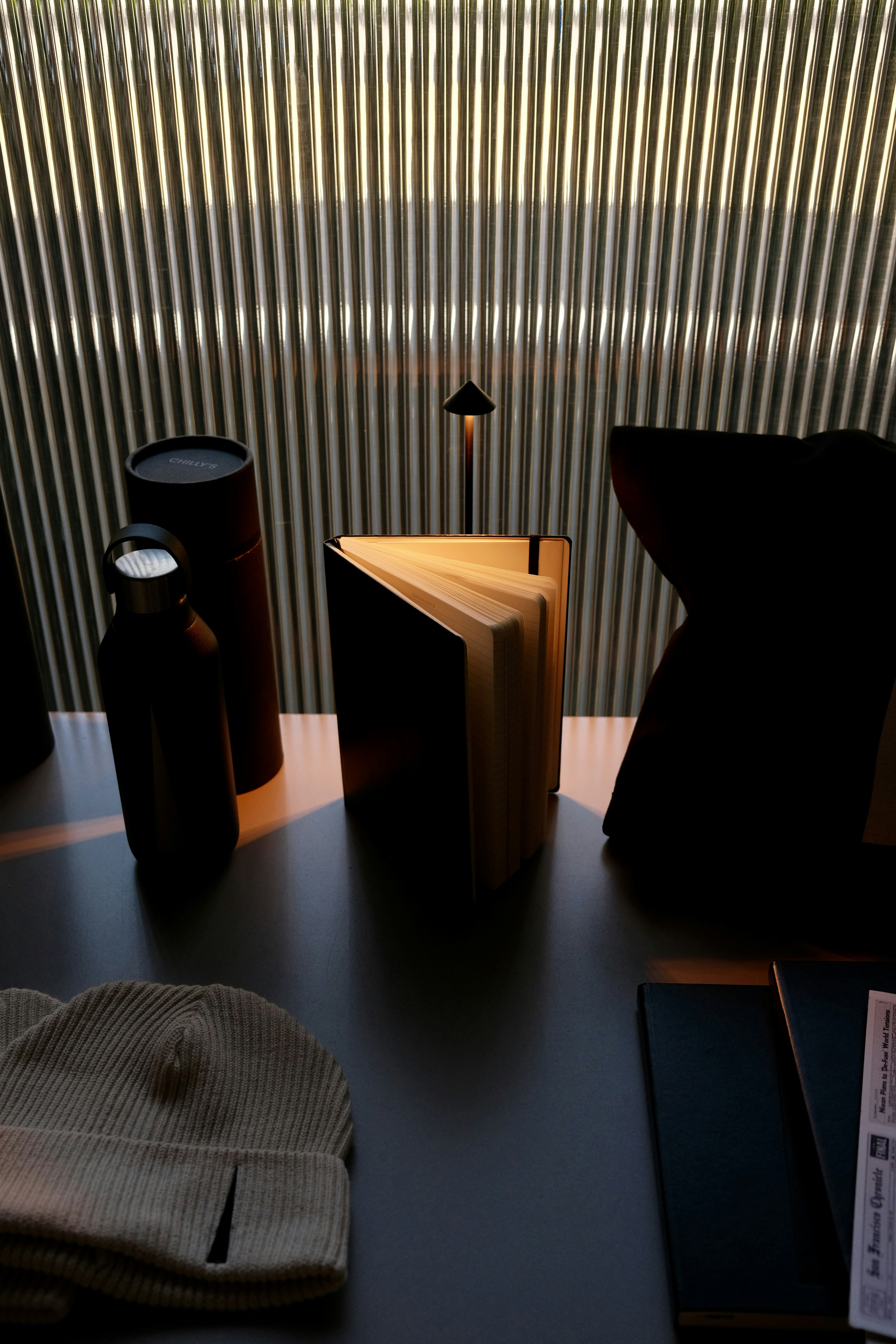 A lit notebook sits among various dark objects. photo – Free Interior ...