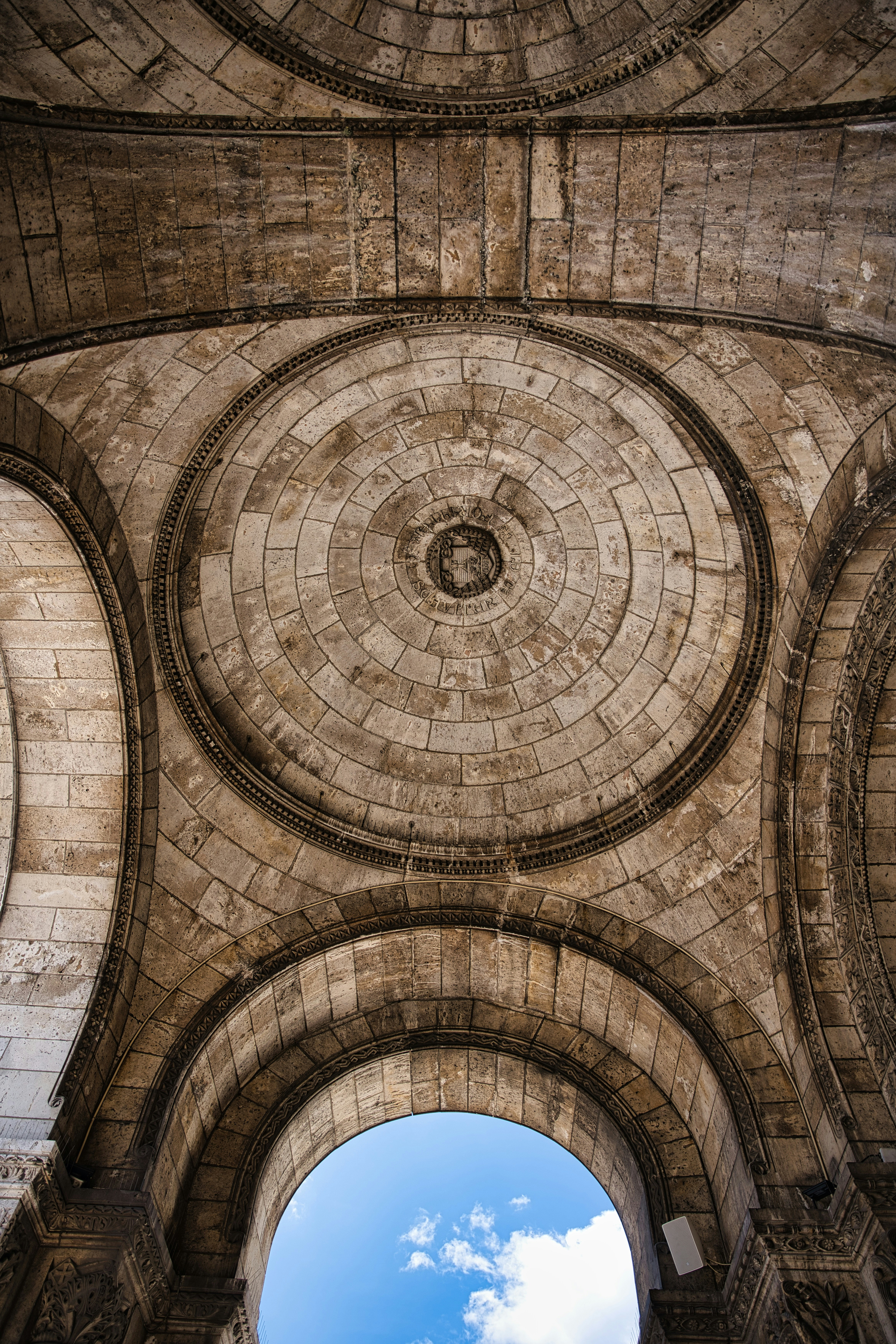 Arched ceiling with a circular design and sky view.