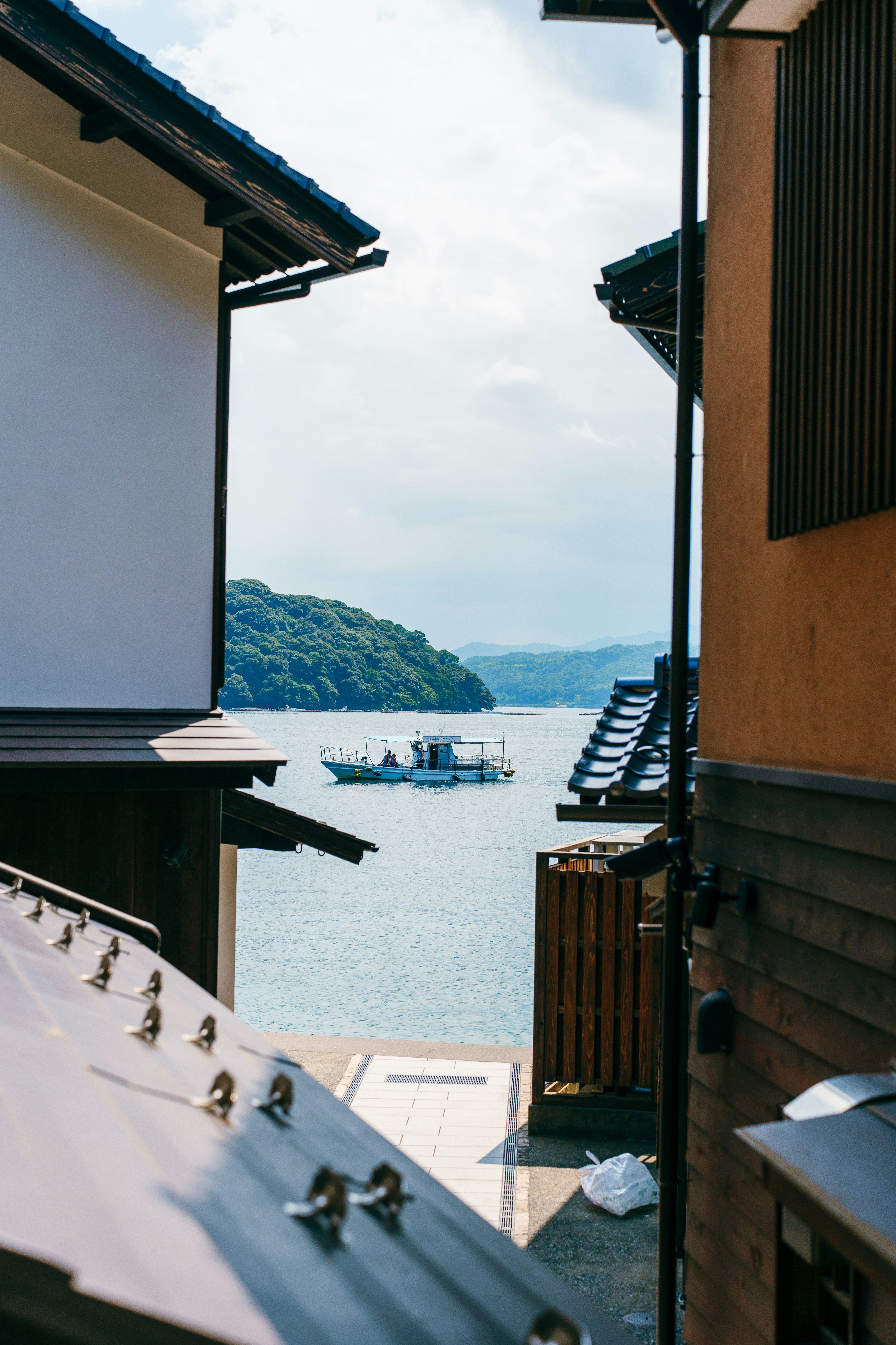 Between Rooflines: A Quiet Boat Emerges on a Lake-Framed Street