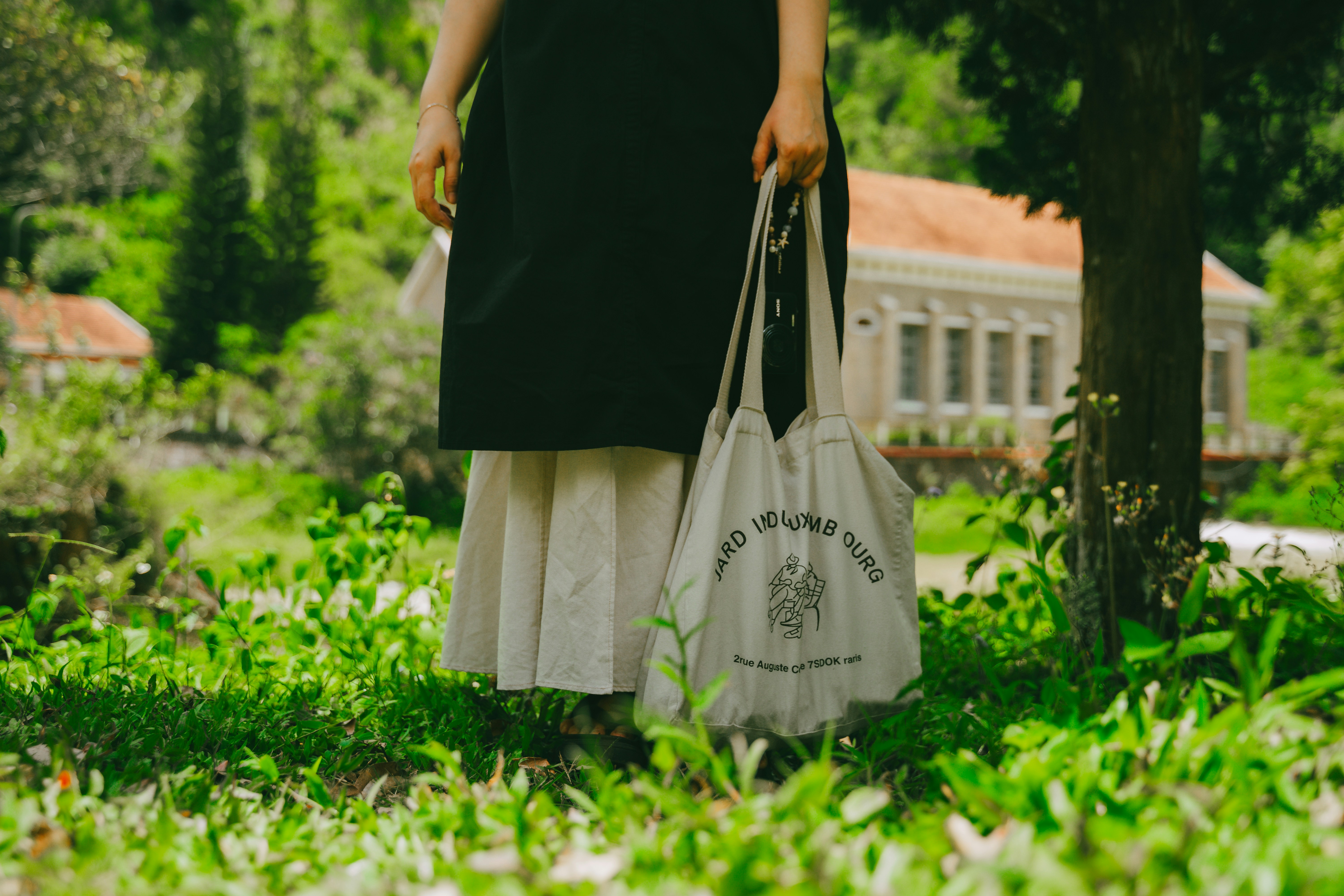A woman holds a bag outdoors.