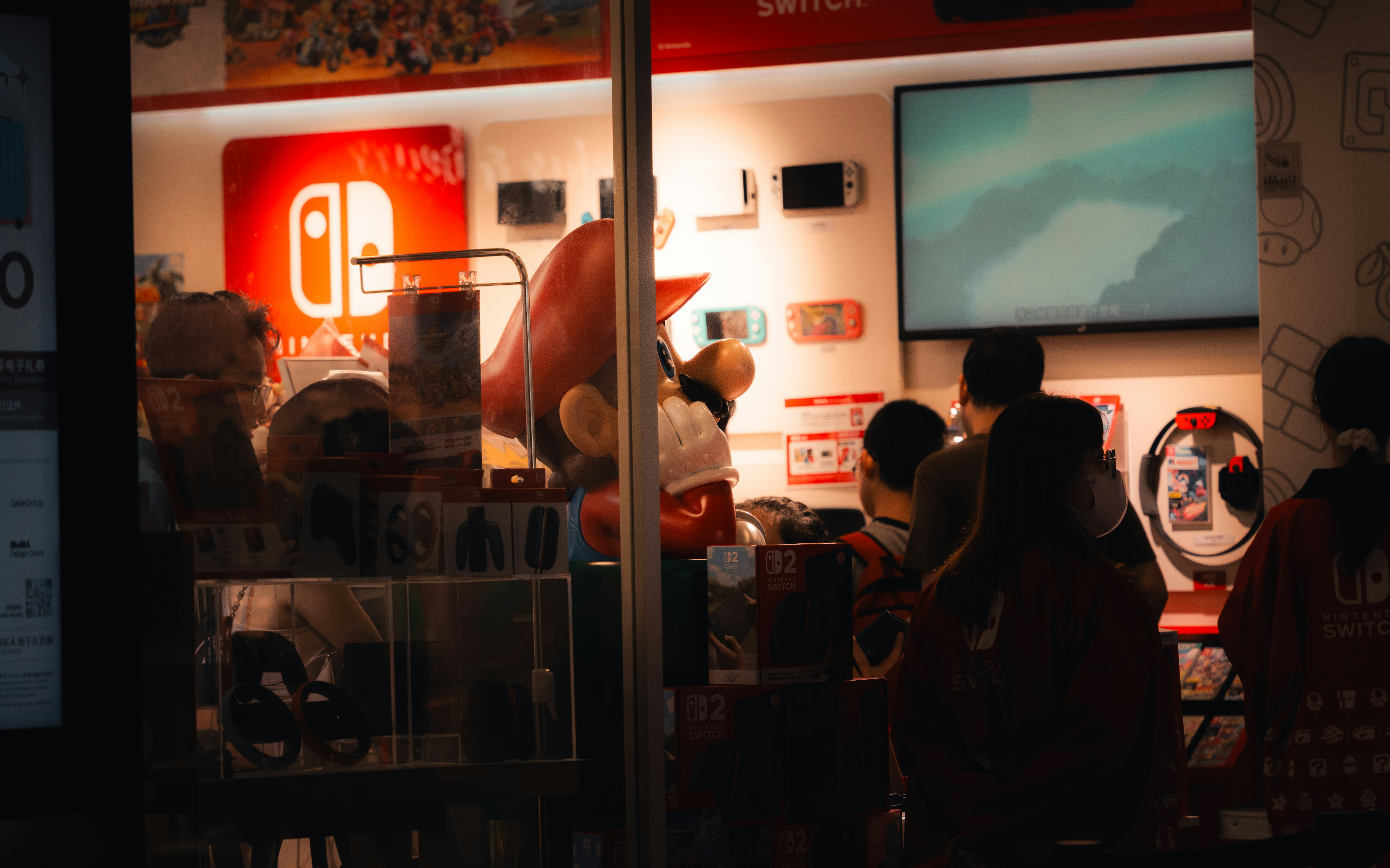 Red Neon Pulse: Crowds at a Nintendo Booth in Low Light