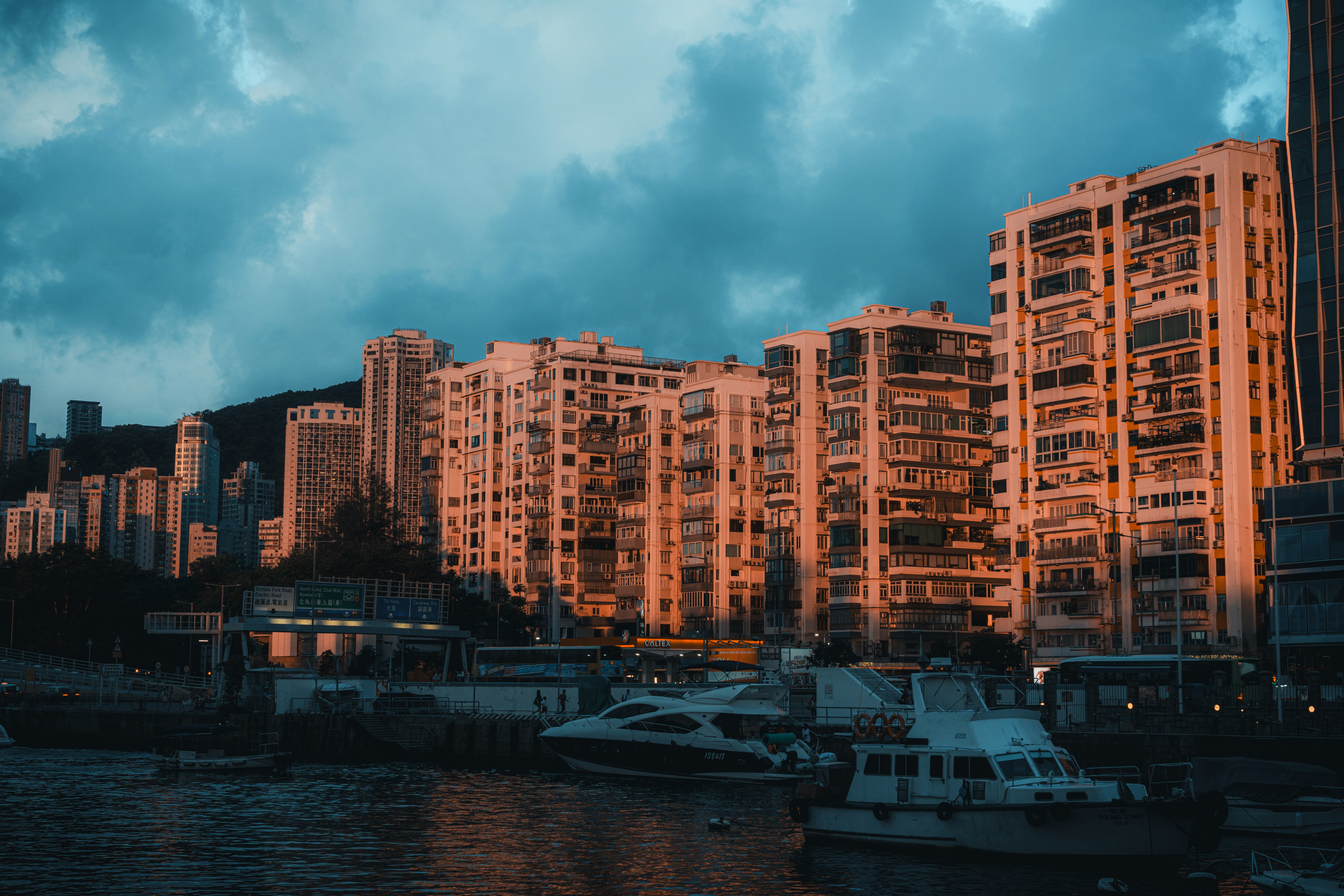 Buildings and boats are lit up by sunset.
