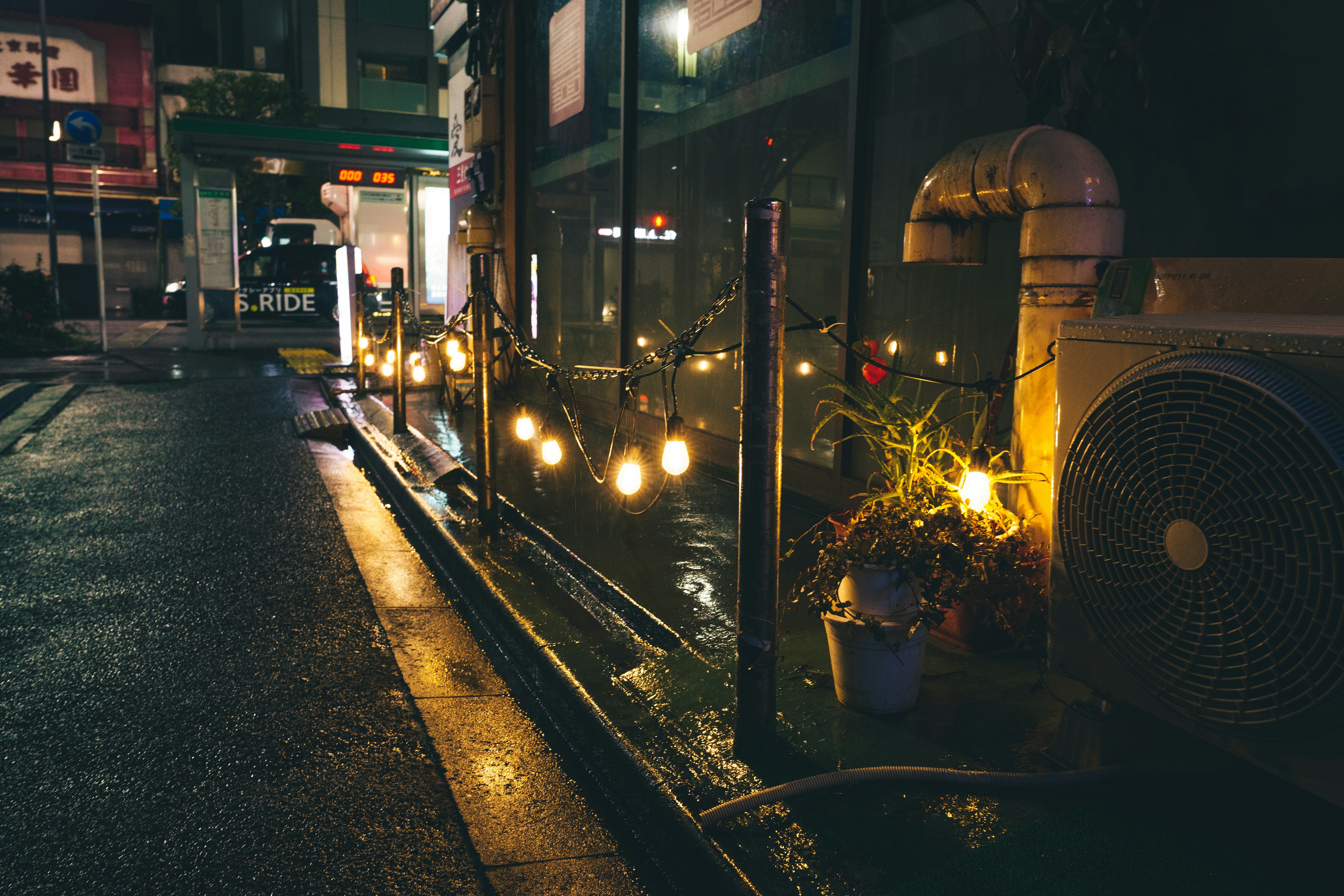 Nighttime street scene with lights and reflections.