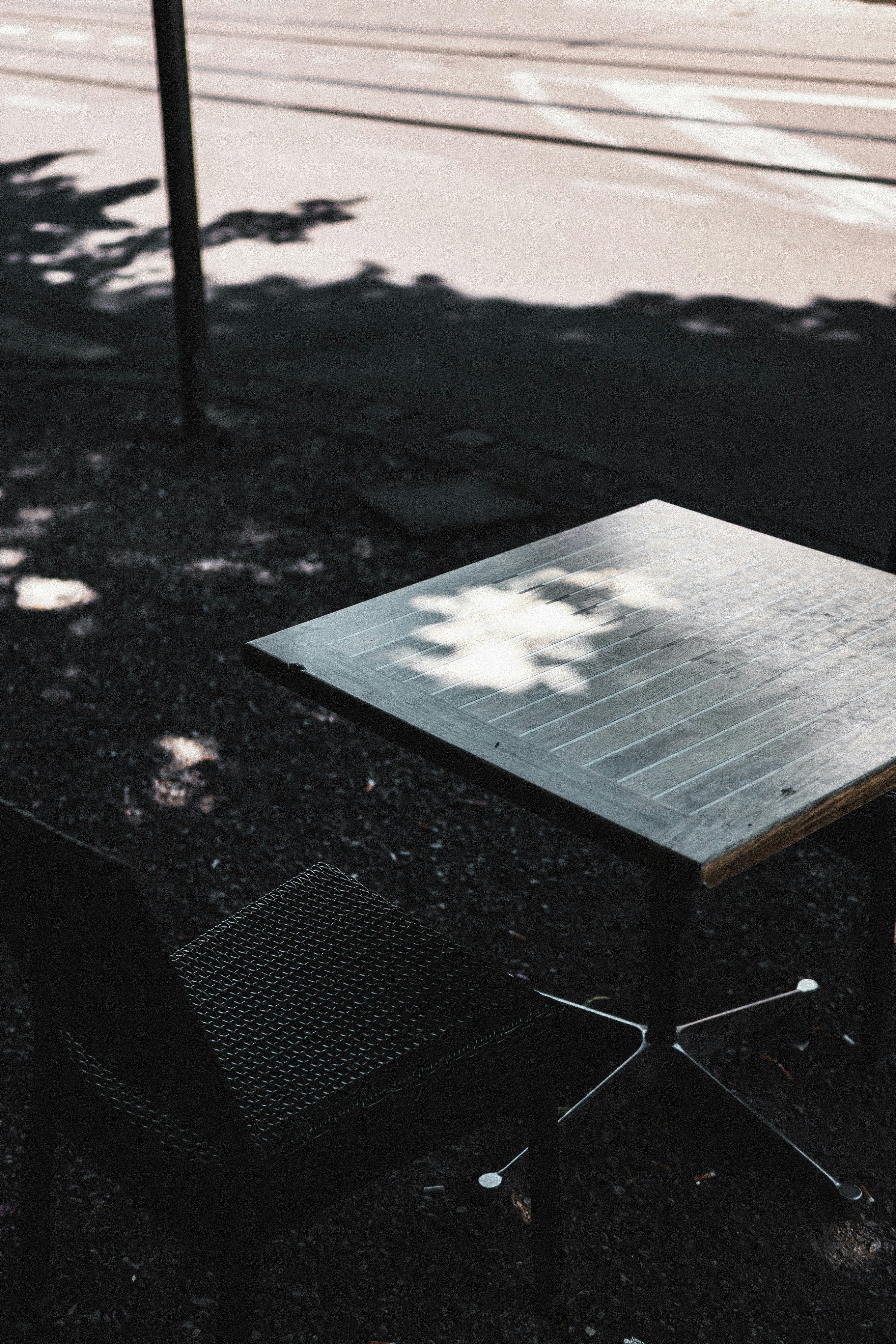 A table and chair sit outside on a sunny day.