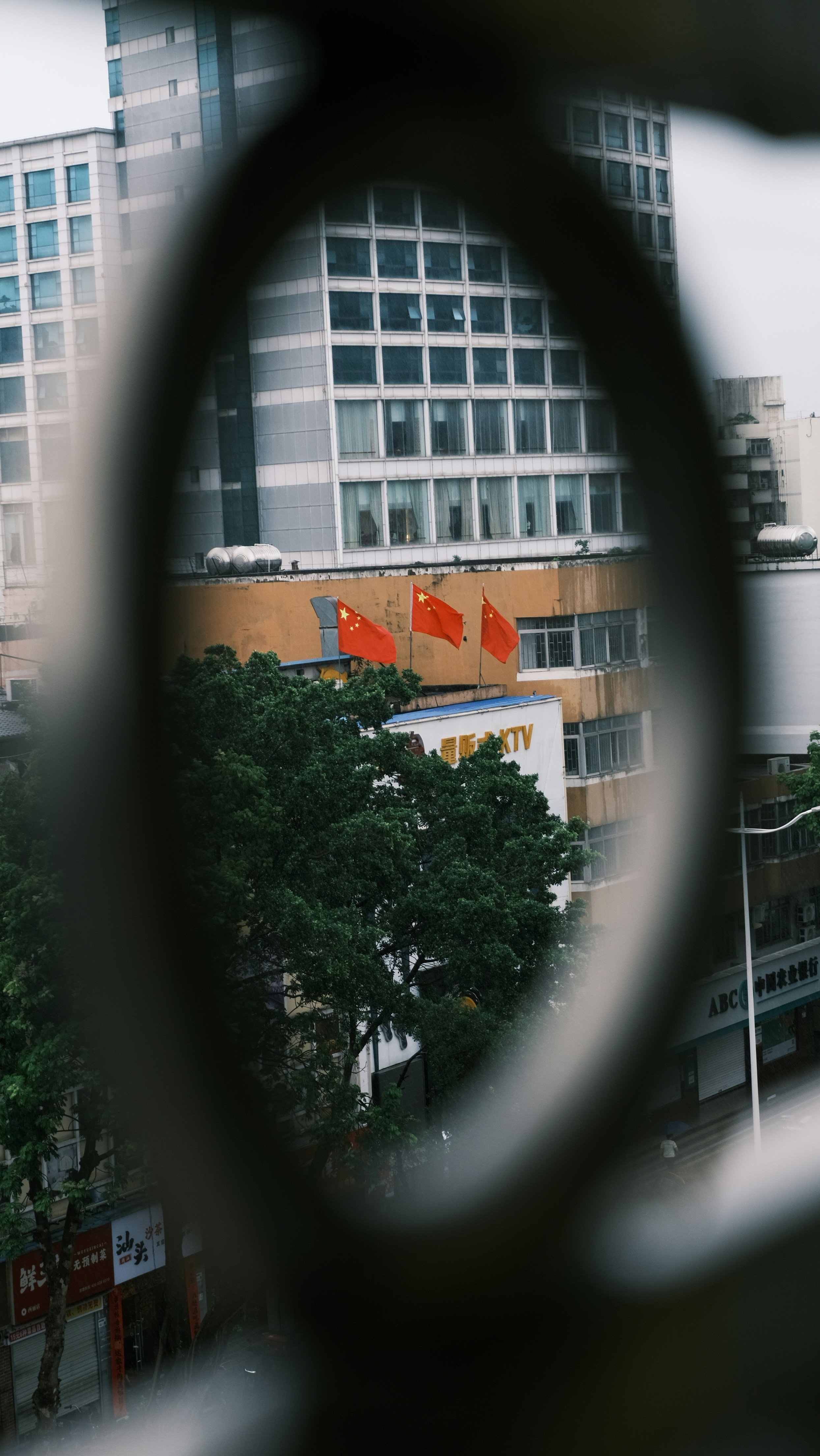 Chinese flags fly over a building.