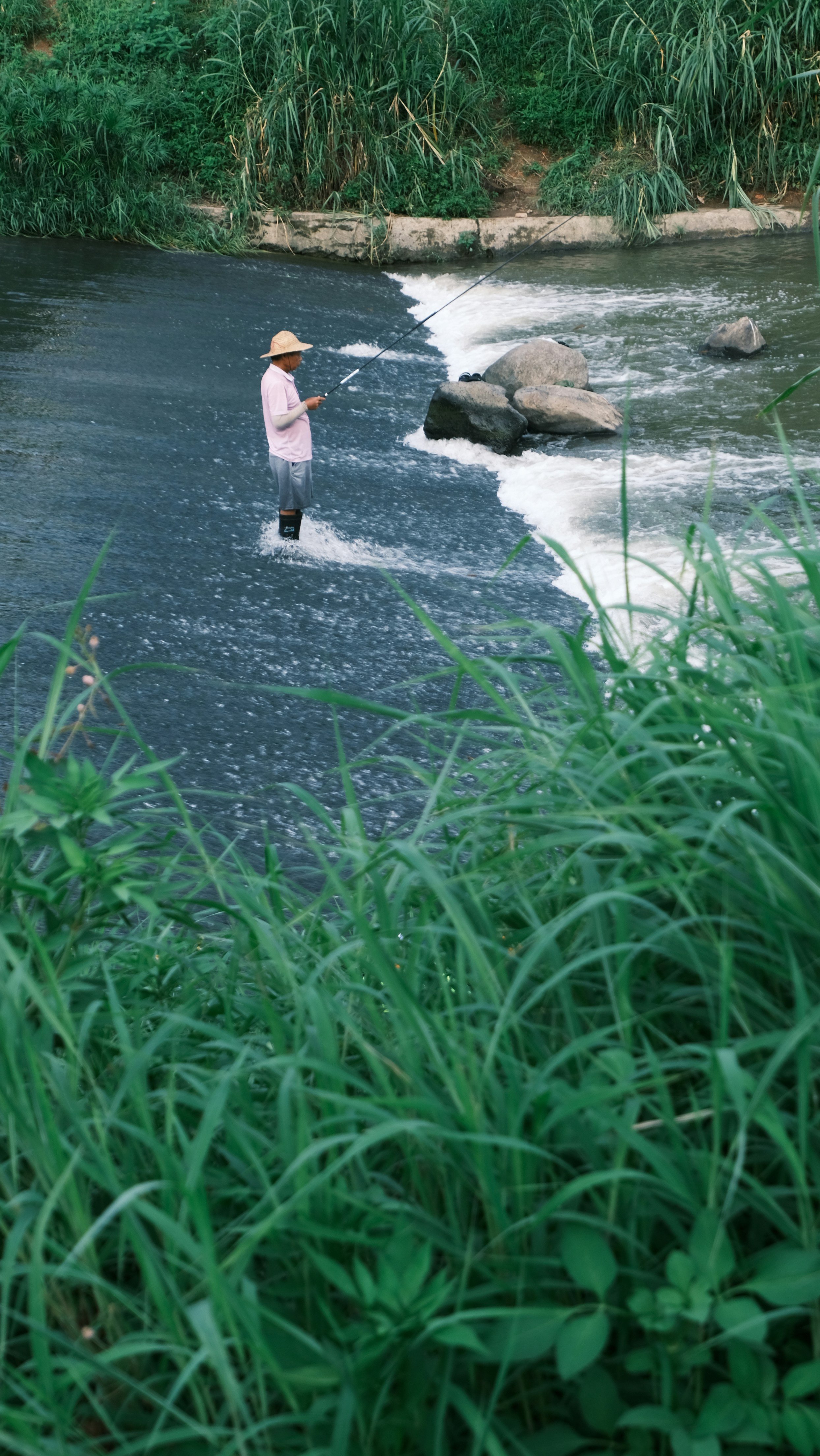 A man is fishing in a river.
