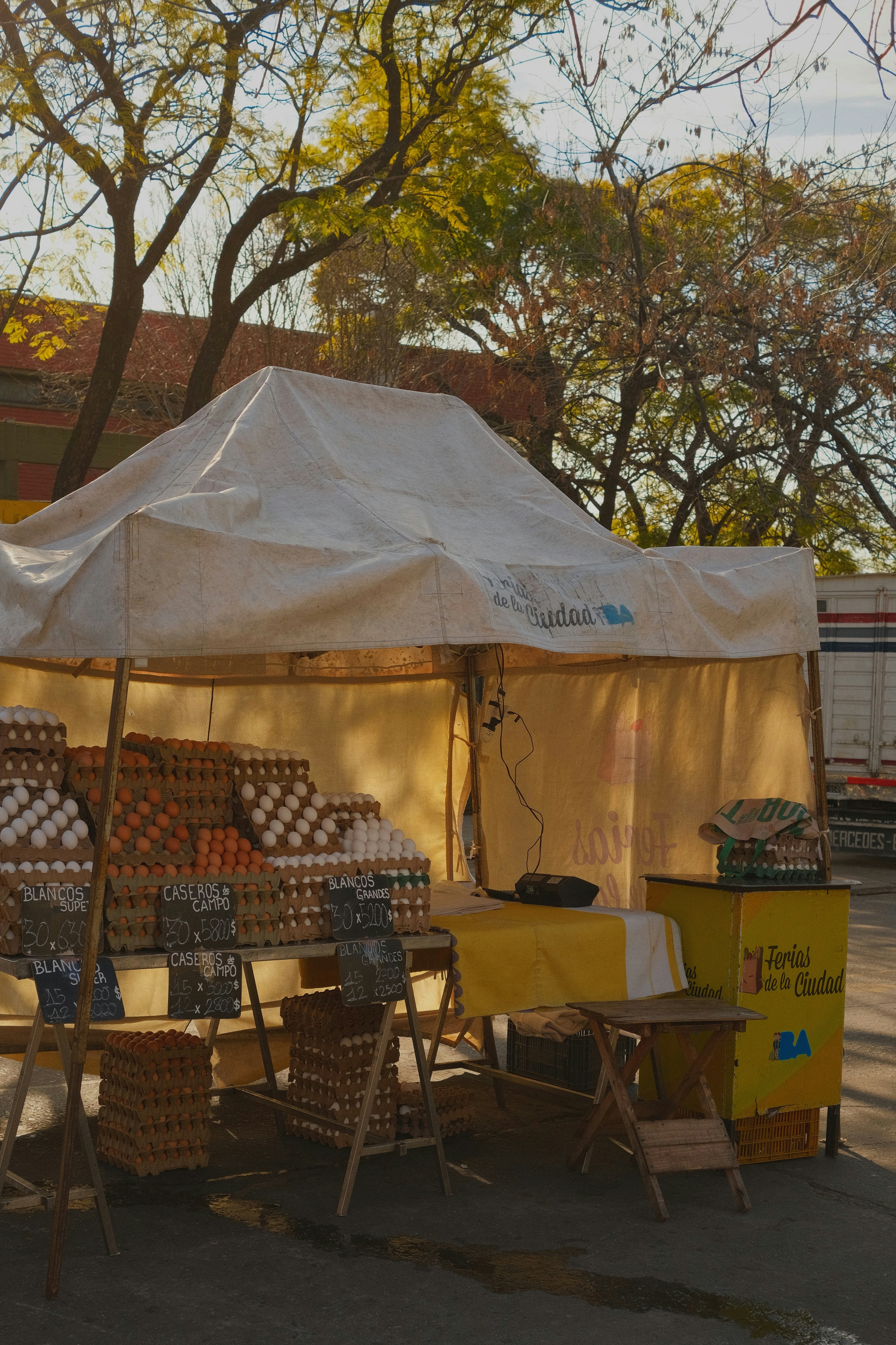 Eggs are sold at a market stall outdoors.