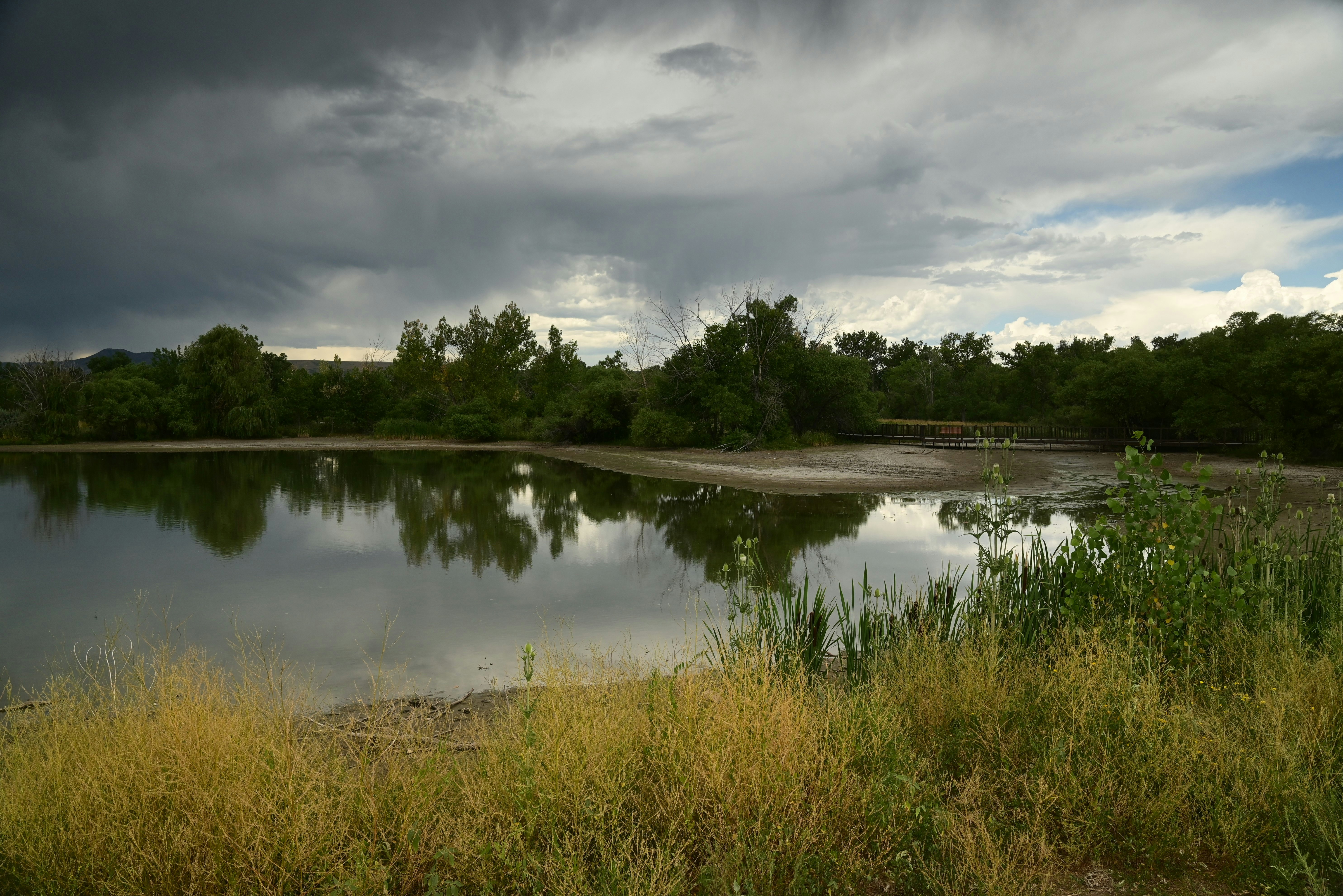 Dark clouds reflect in the still water.