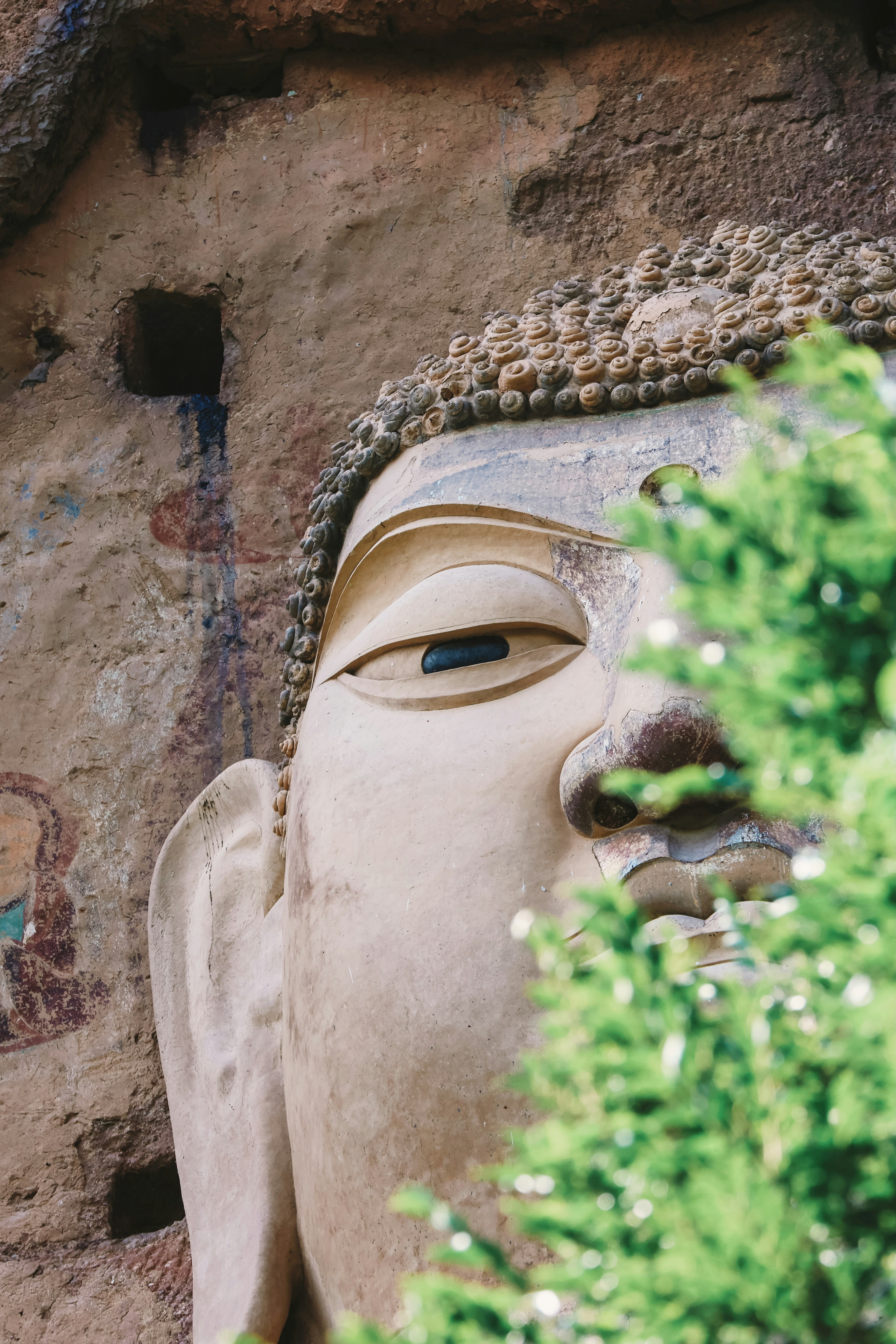 Created with RNI Films app. Profile 'Agfa Optima 200 Warm' | A stone buddha head with partially closed eyes.