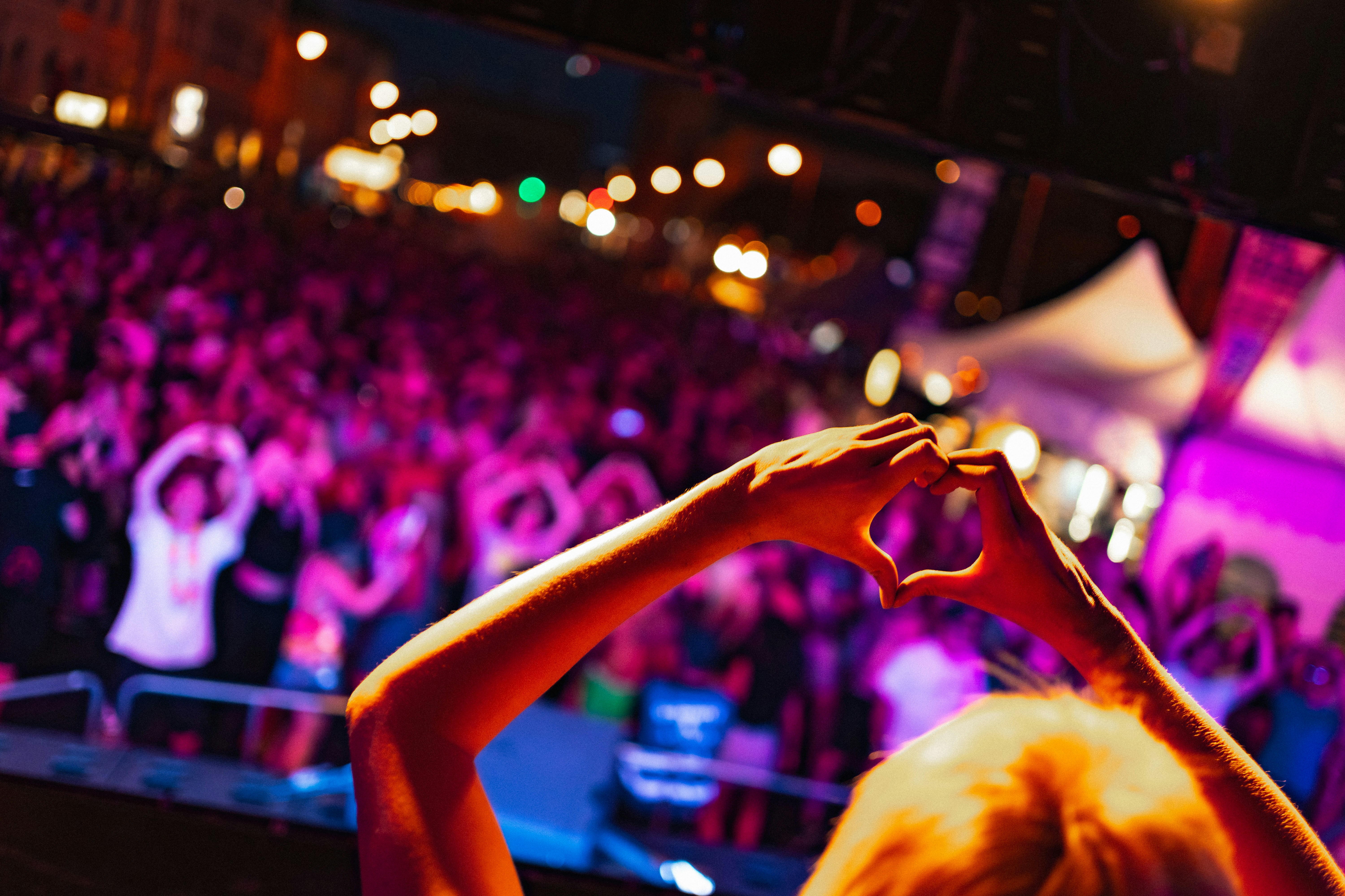 Hands-Curved Heart Over a Thunderous Crowd