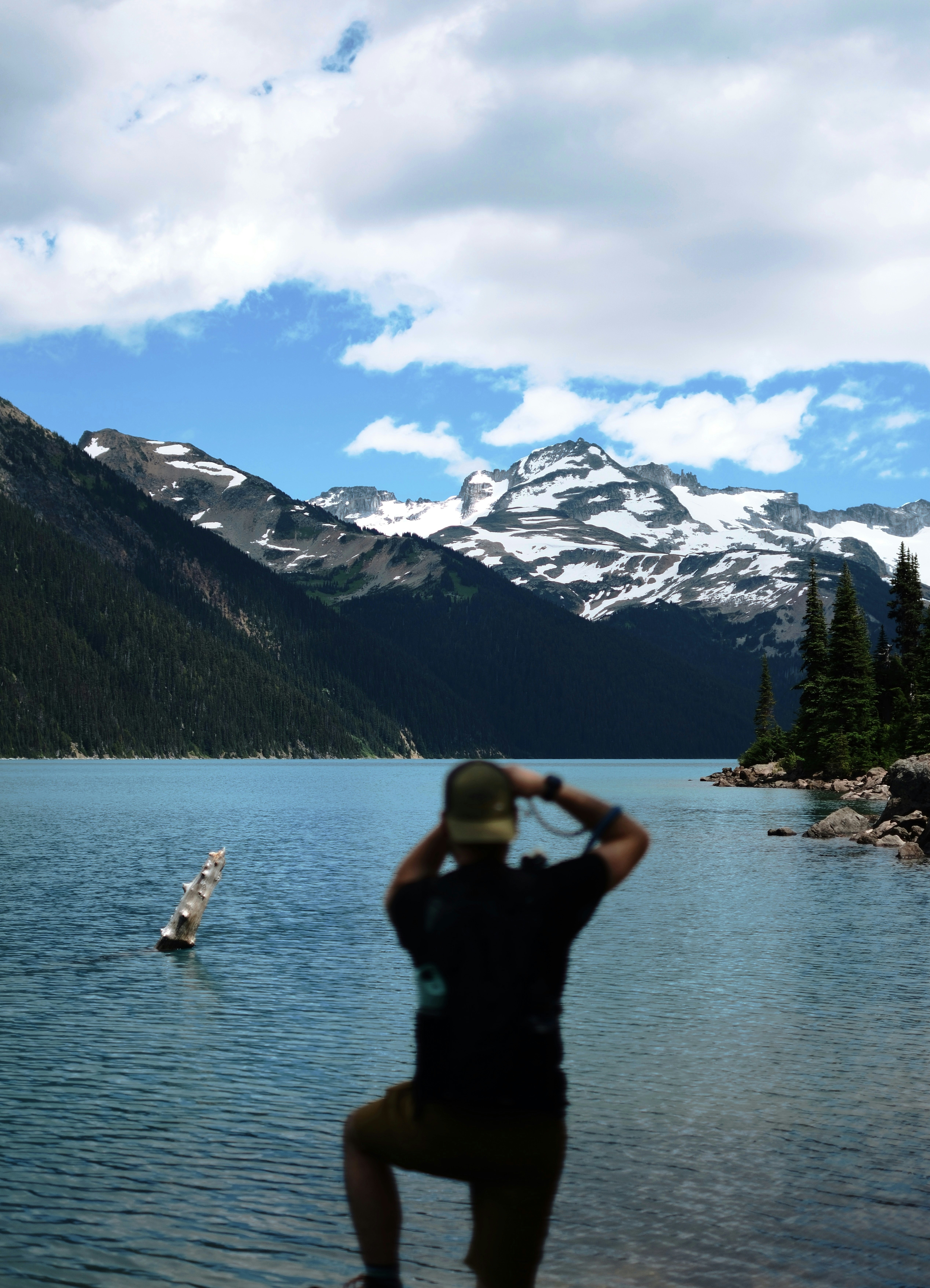 Silhouette of a Photographer at Mirror Lake Under Snowcapped Peaks