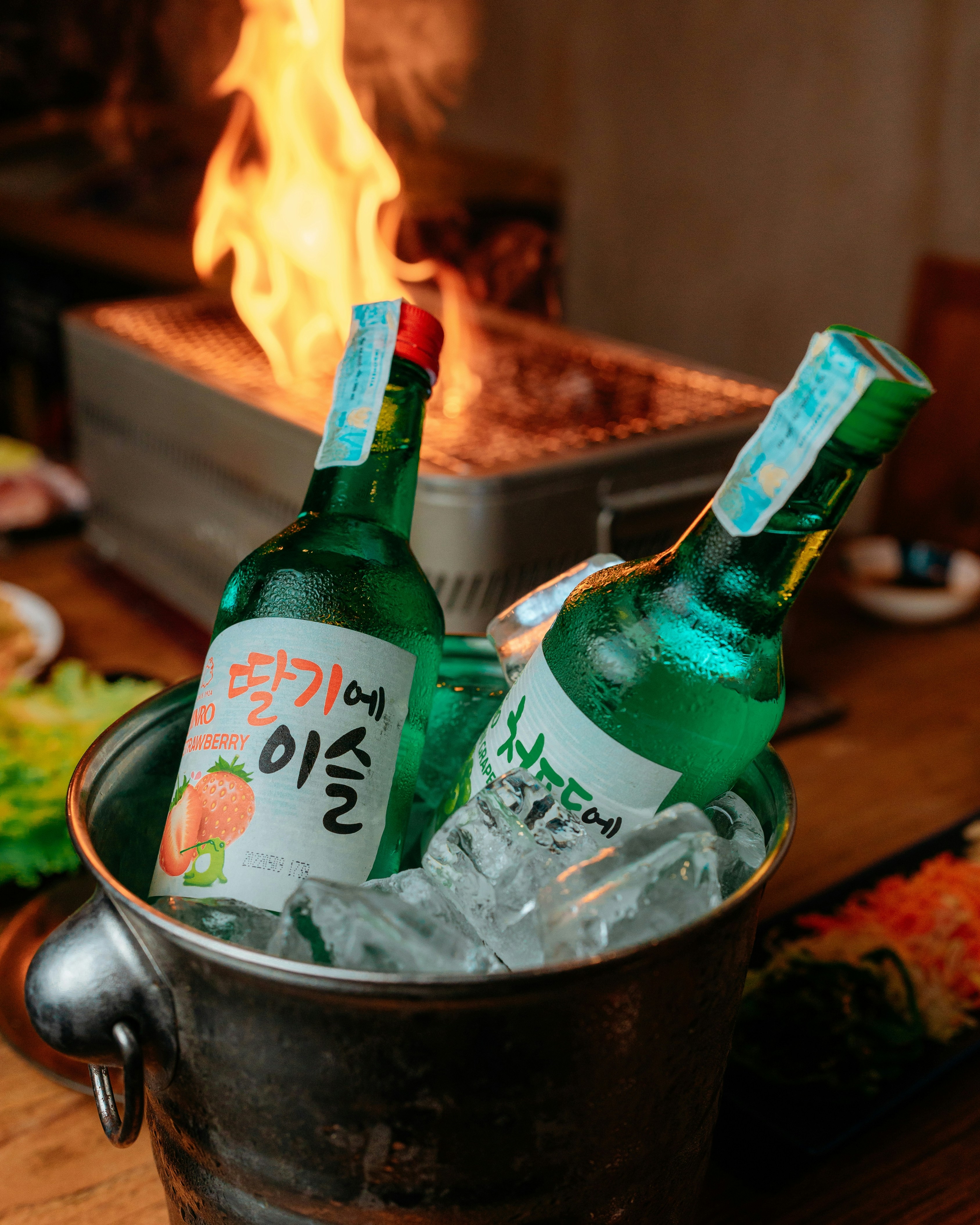 Korean soju bottles chilled in ice with grill background. photo – Free ...