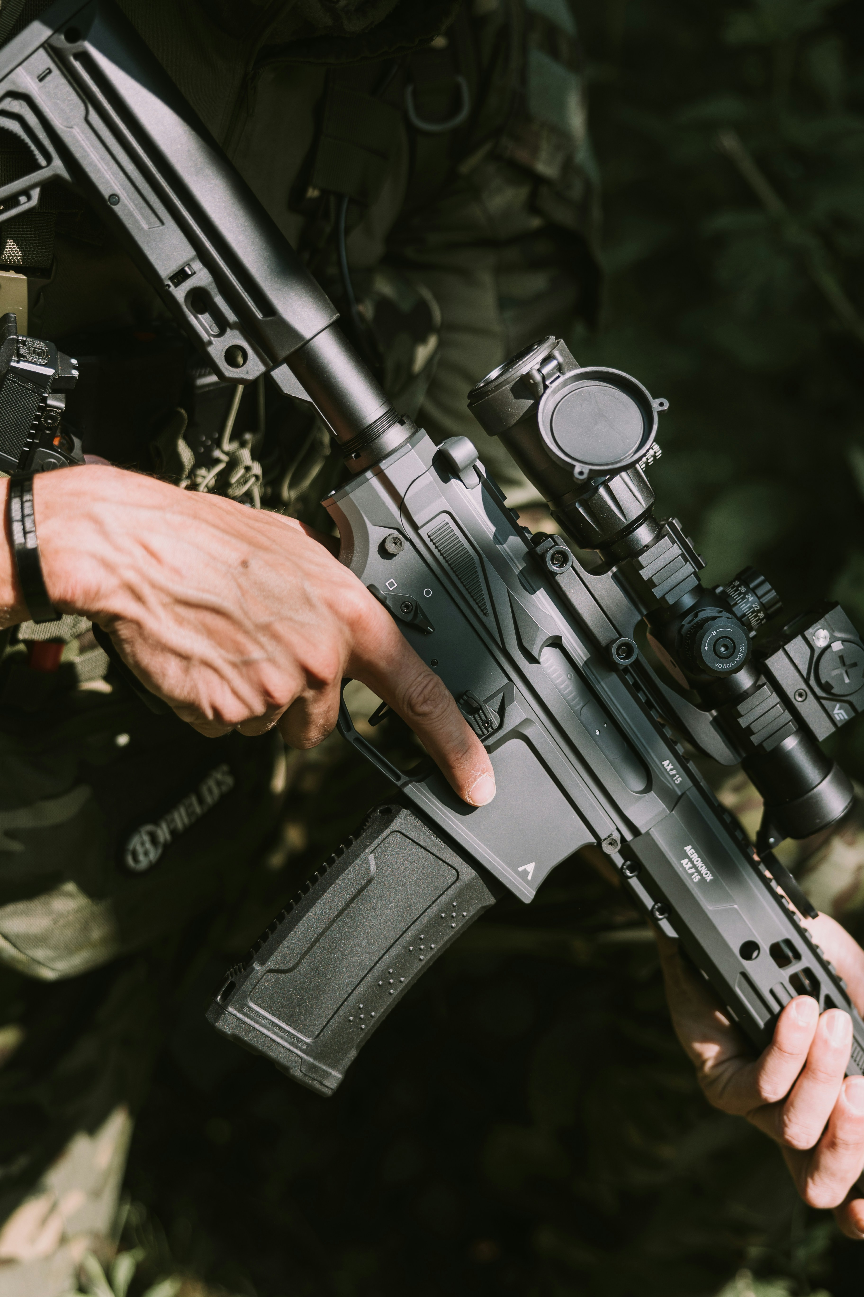 A person is holding a rifle with a scope. photo – Free Tactical Image ...