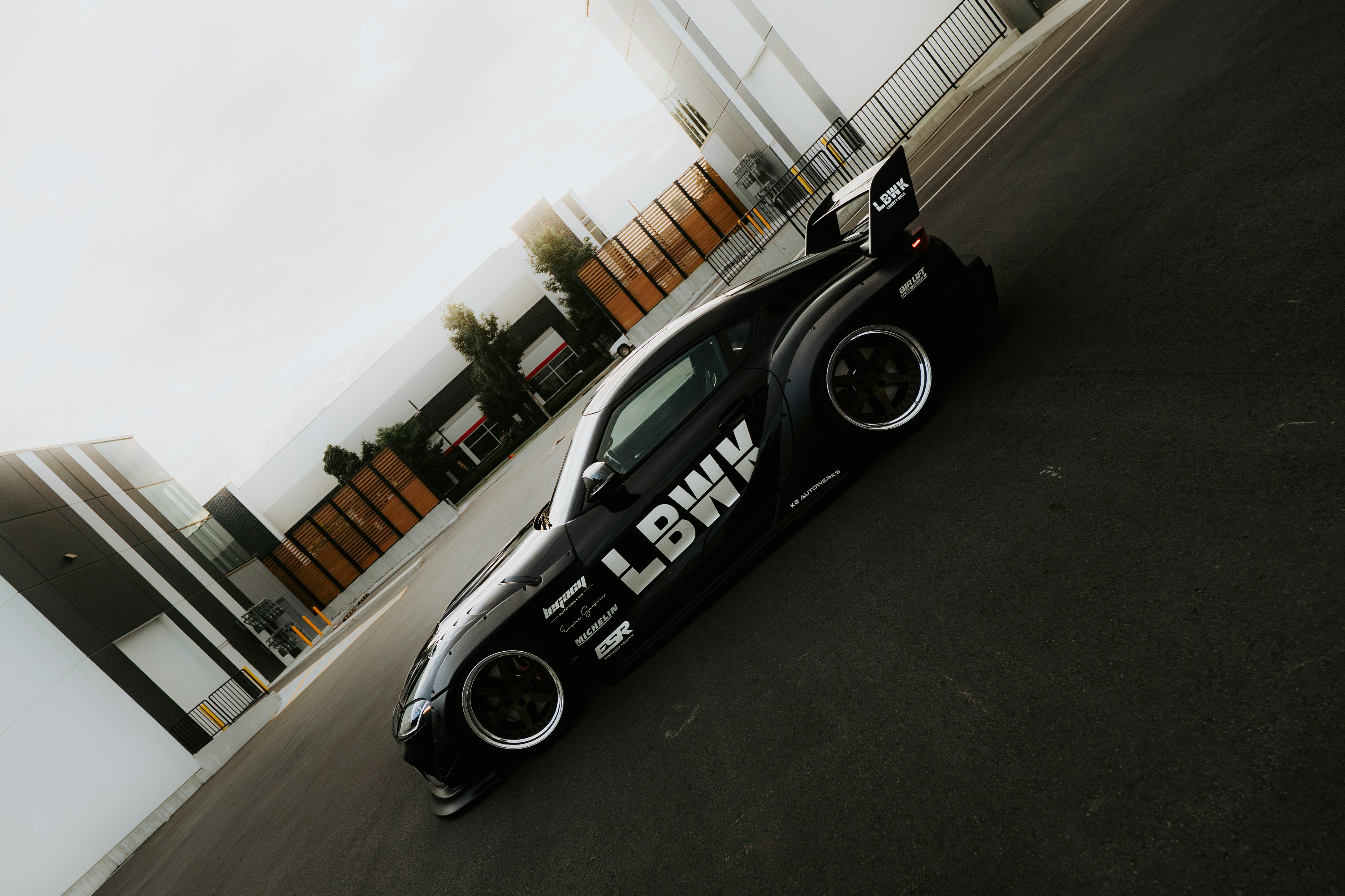 Low-Slung Racer Beside Modern Facades
