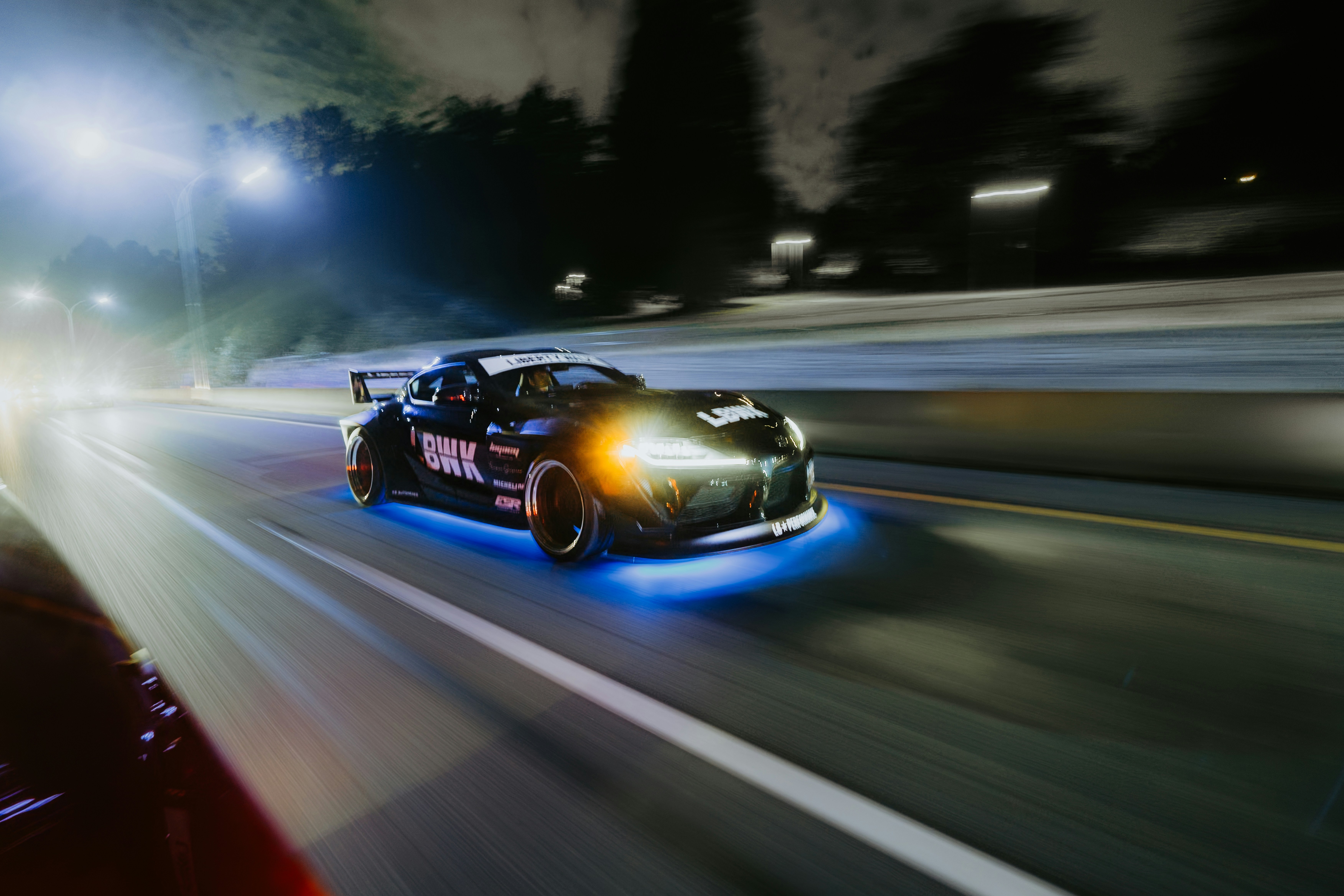 A fast car races down the street at night.