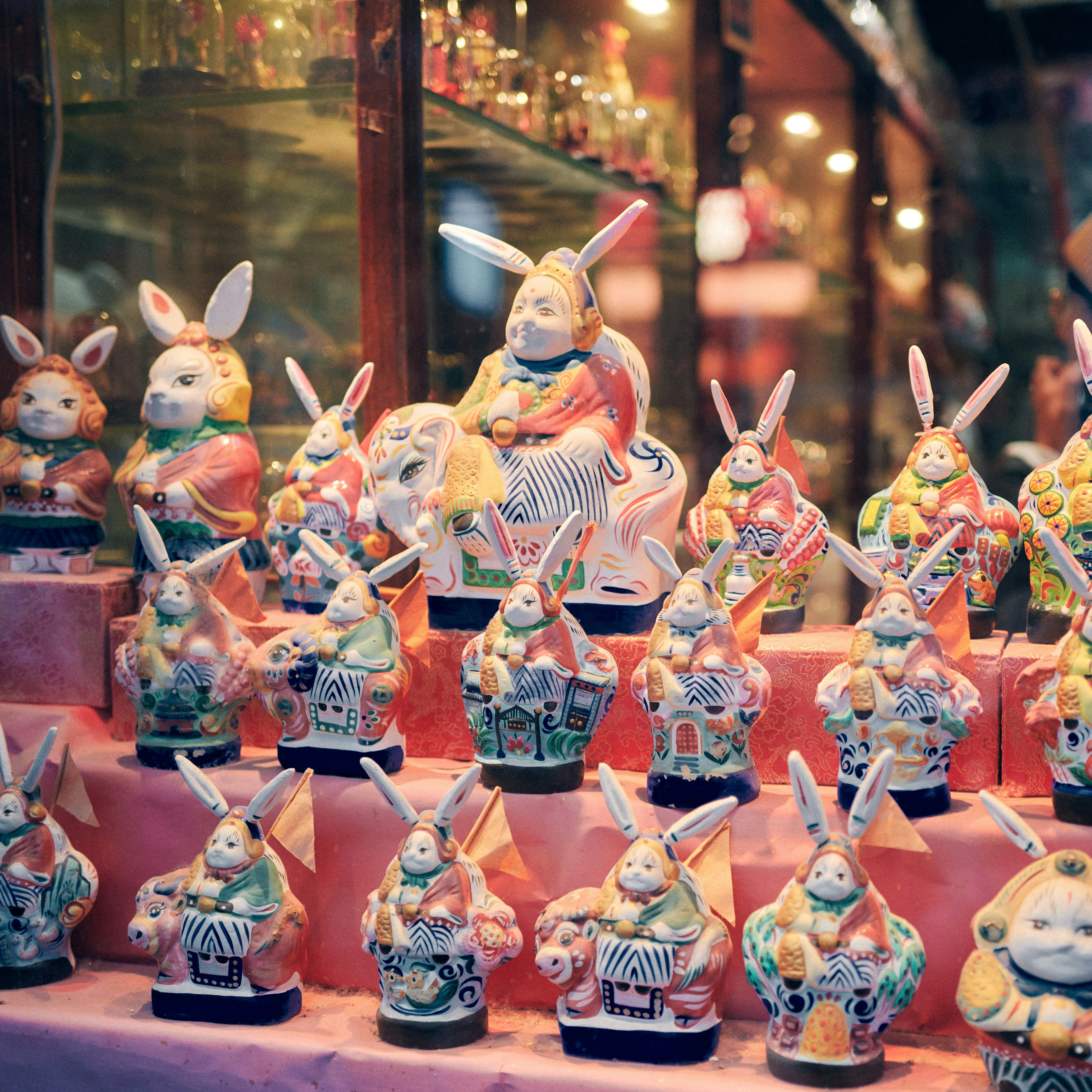 Colorful ceramic figurines arranged in a display, showcasing intricate designs and playful themes. Each piece features unique elements, contributing to a vibrant visual narrative.