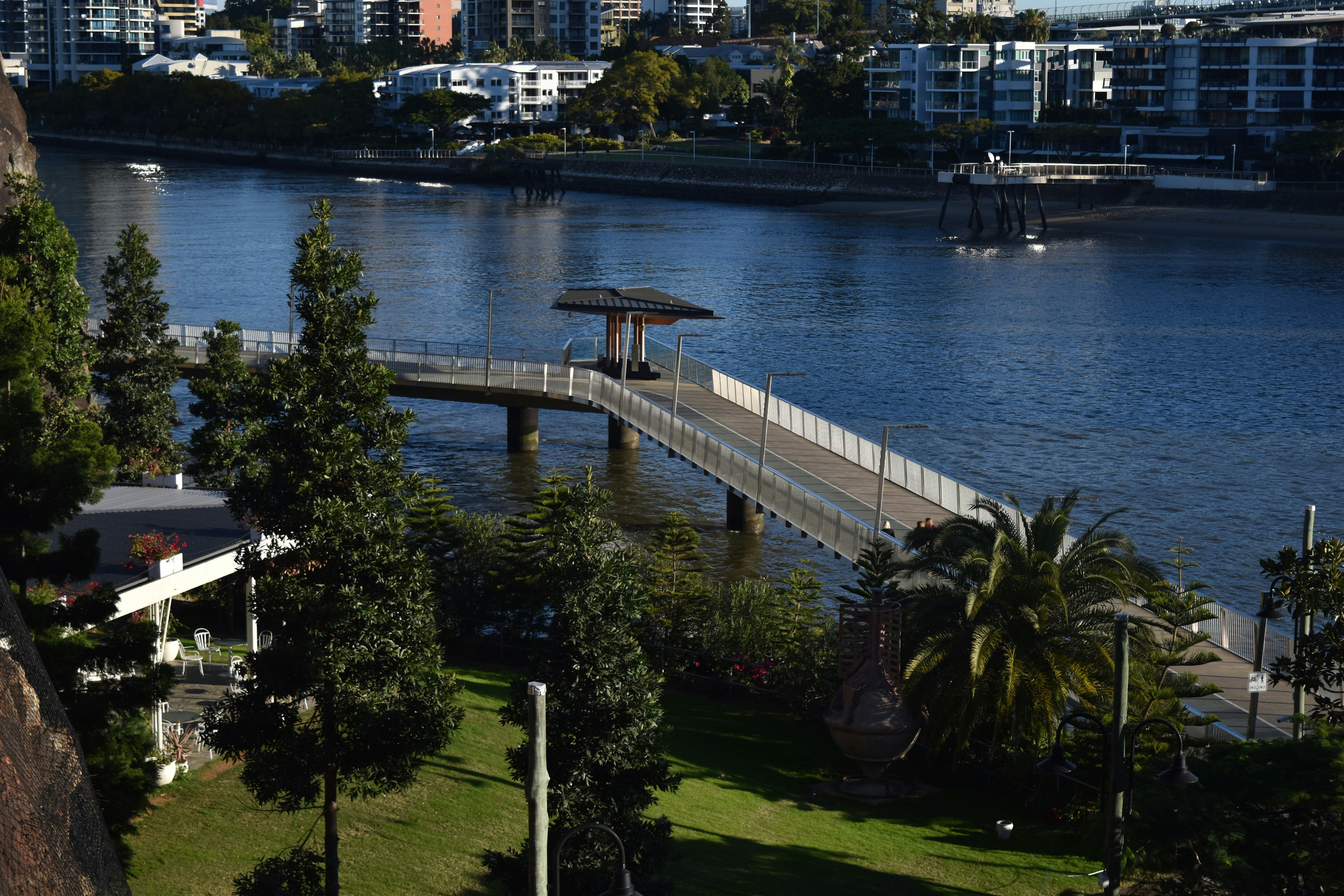 A pier extends into a river in a city.
