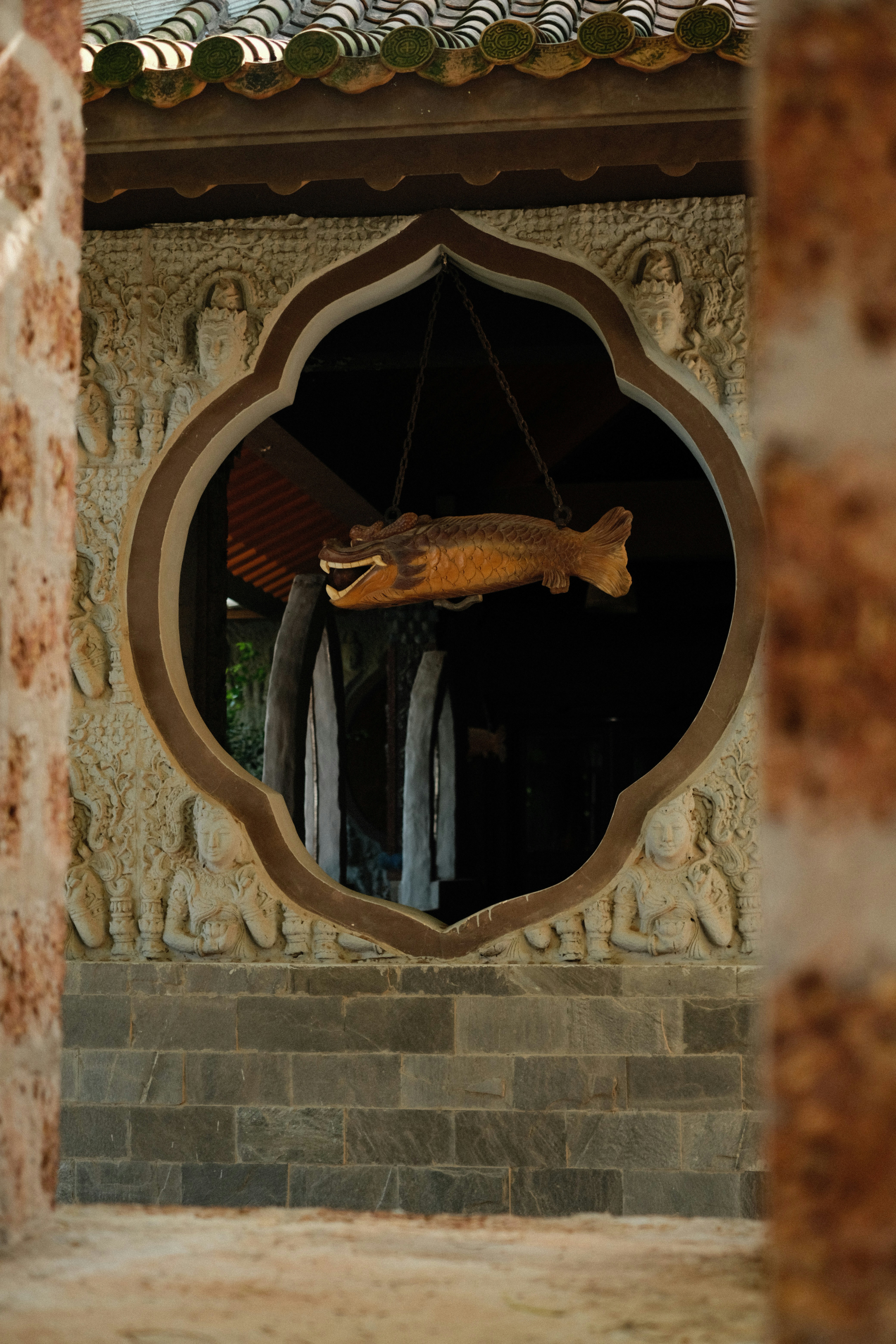 Hanging Dragon: A carved doorway frames a suspended sculpture inside a temple