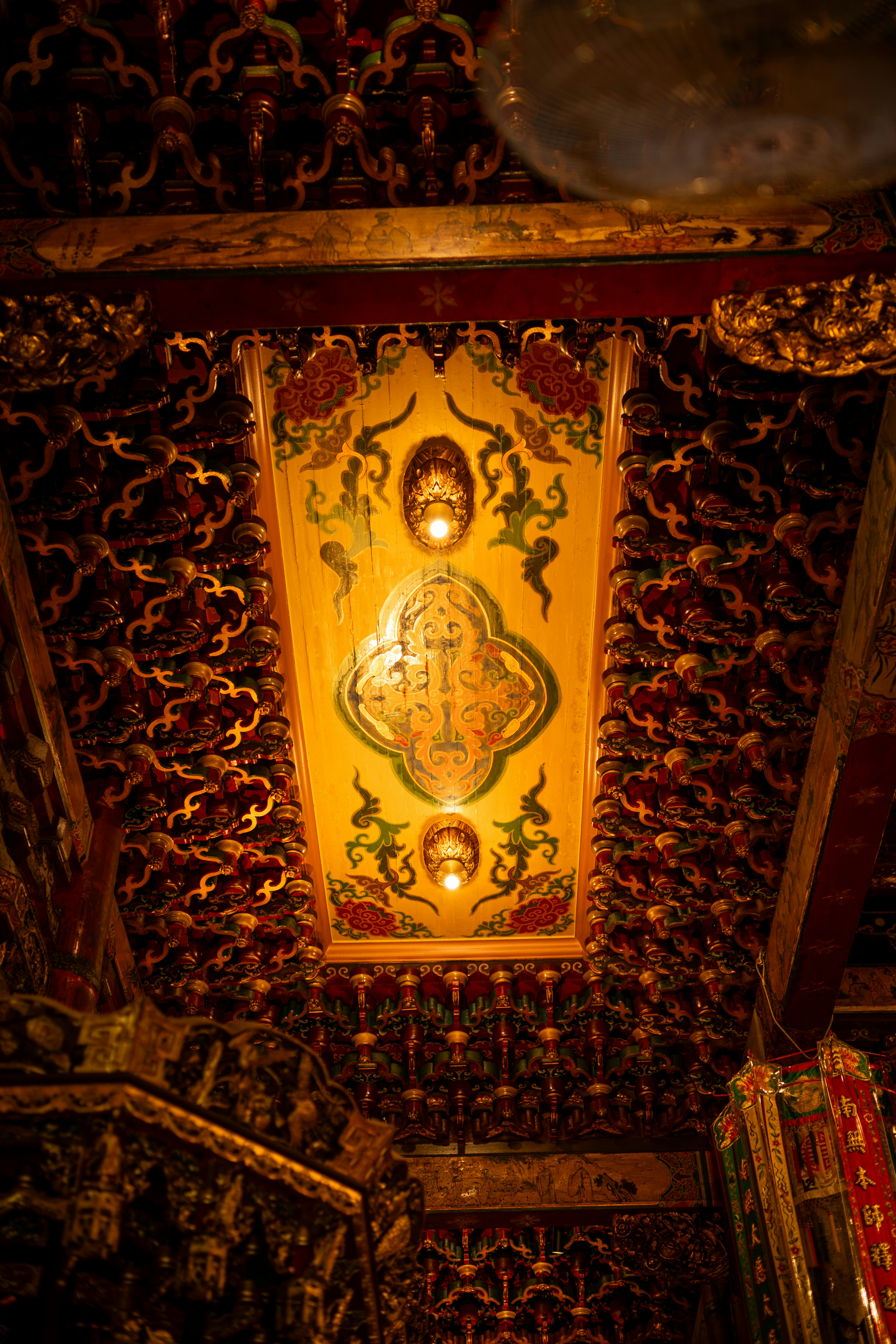 Intricate ceiling adorned with vibrant patterns and ornate details, showcasing the artistry of traditional architecture. Soft lighting enhances the colors and textures.