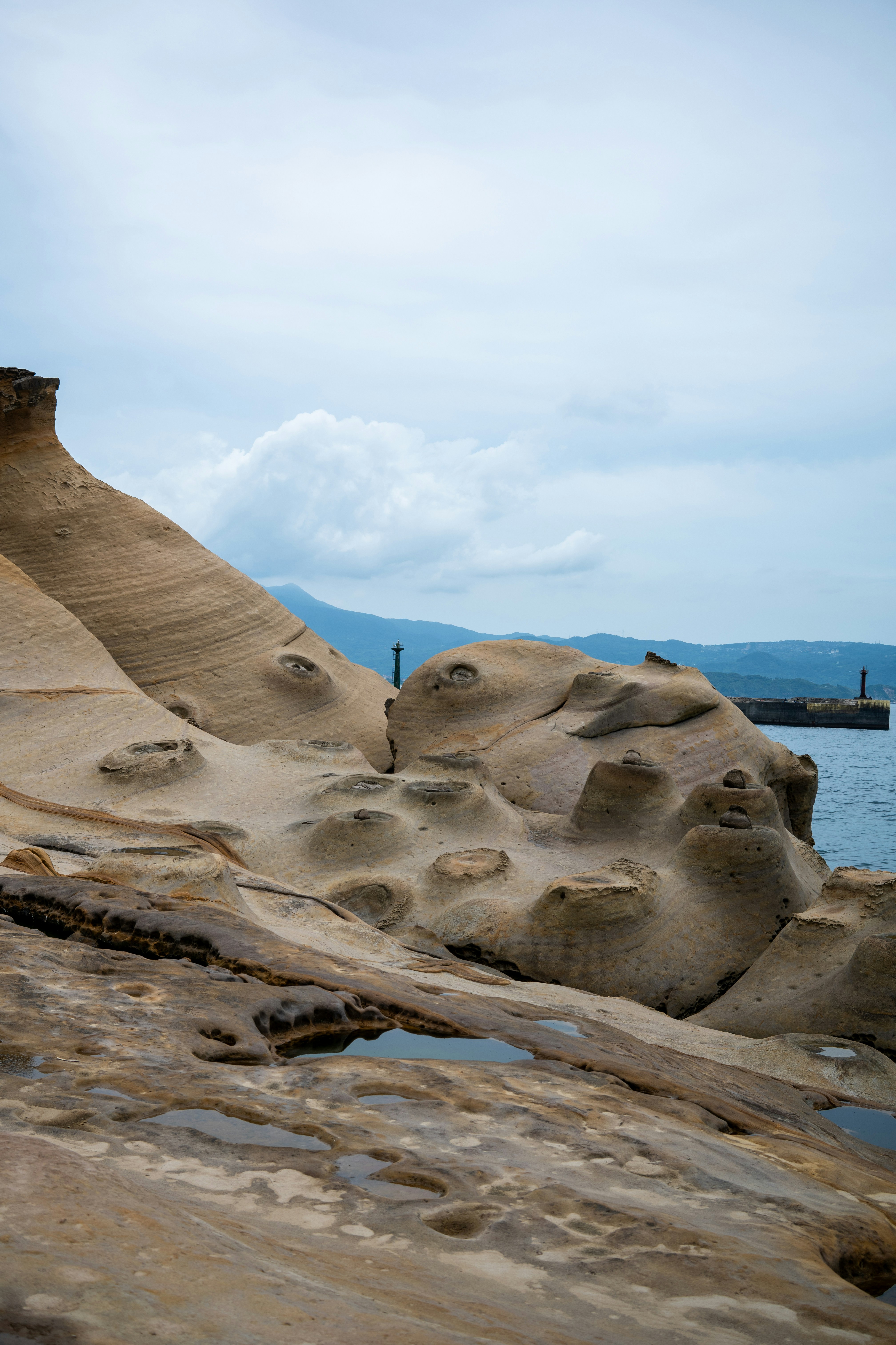 Honeycomb Horizons: Wind-Worn Cliffs Guard the Calm Sea