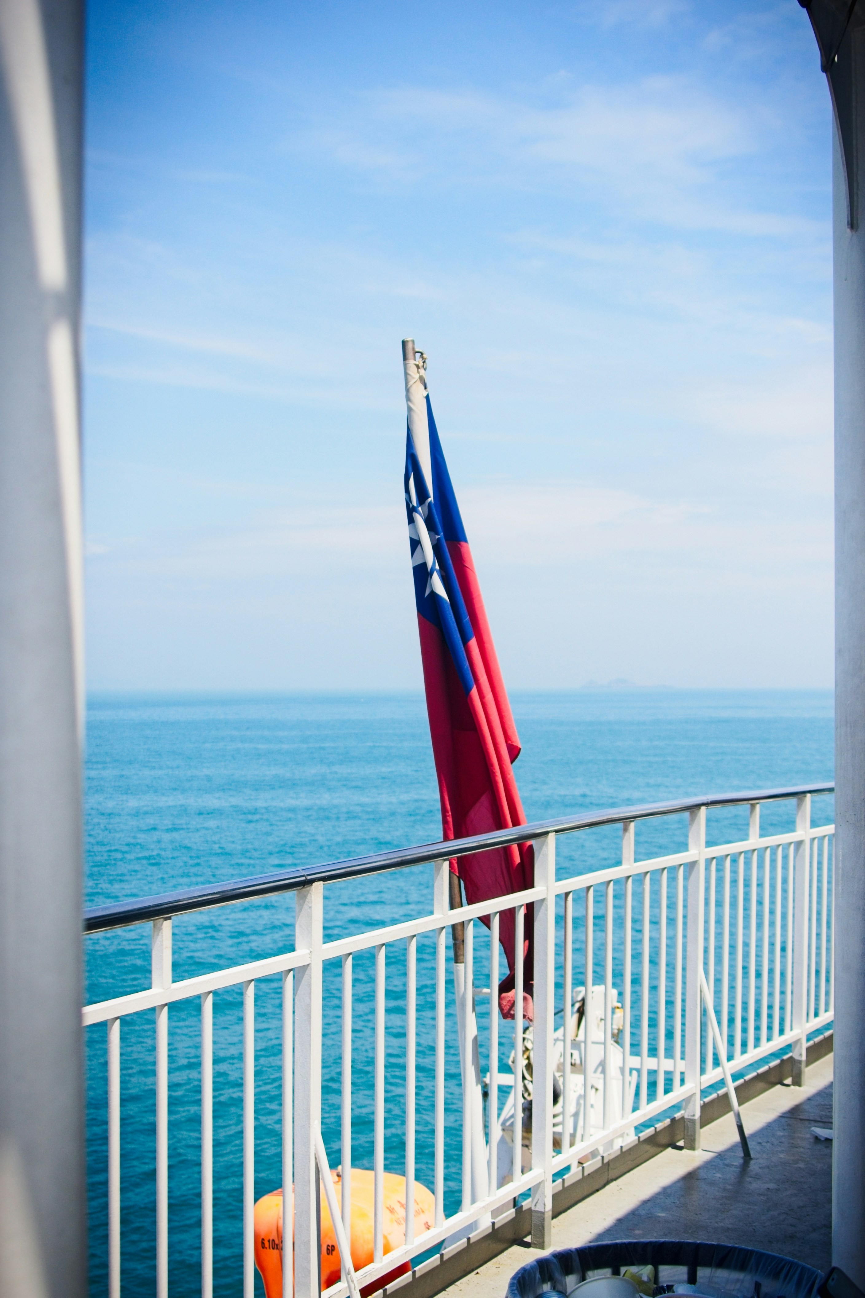 A Taiwan flag hanging at the back of the boat. | A taiwanese flag waves over the ocean.