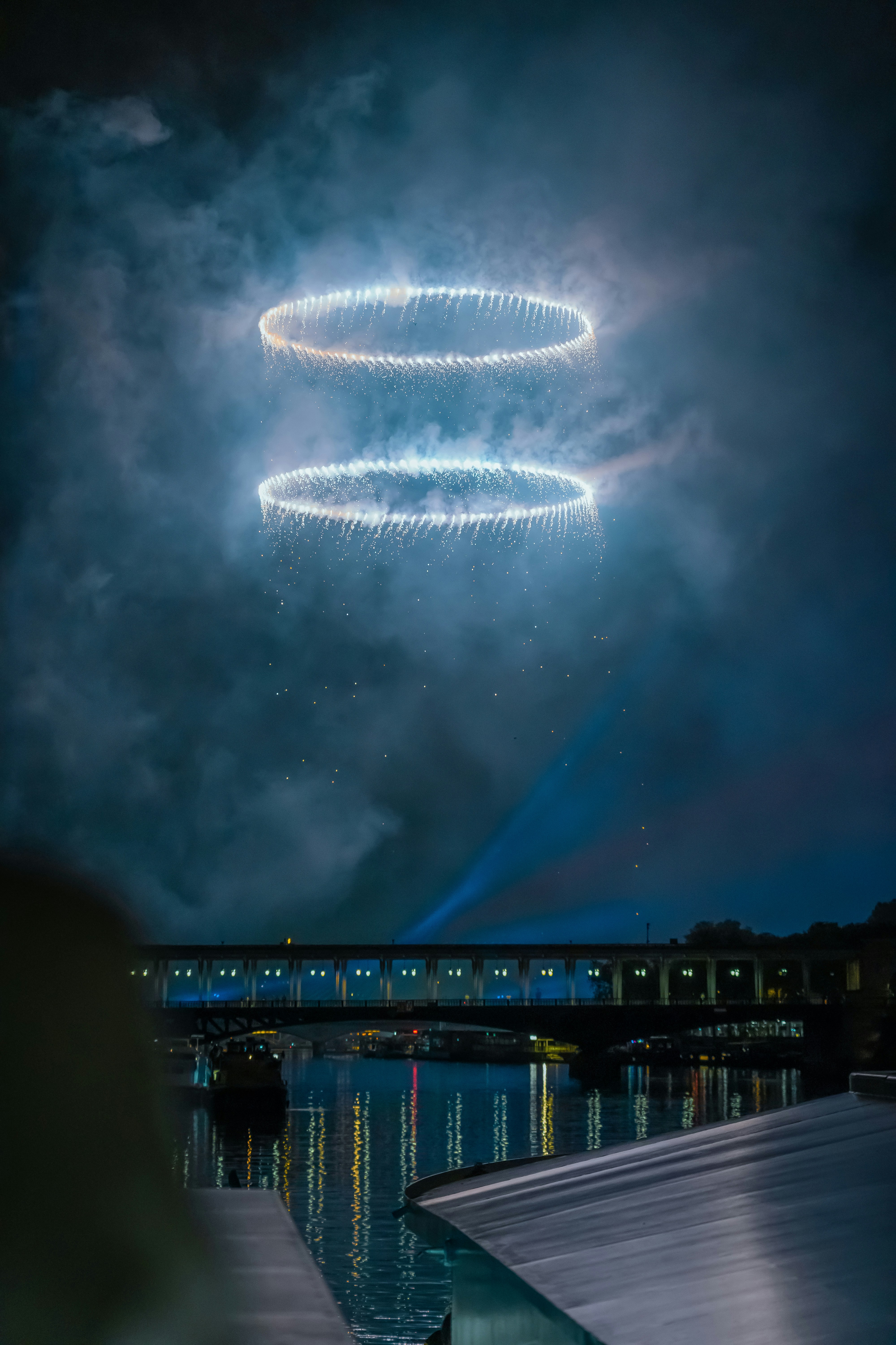Fireworks illuminate the night sky with glowing rings.