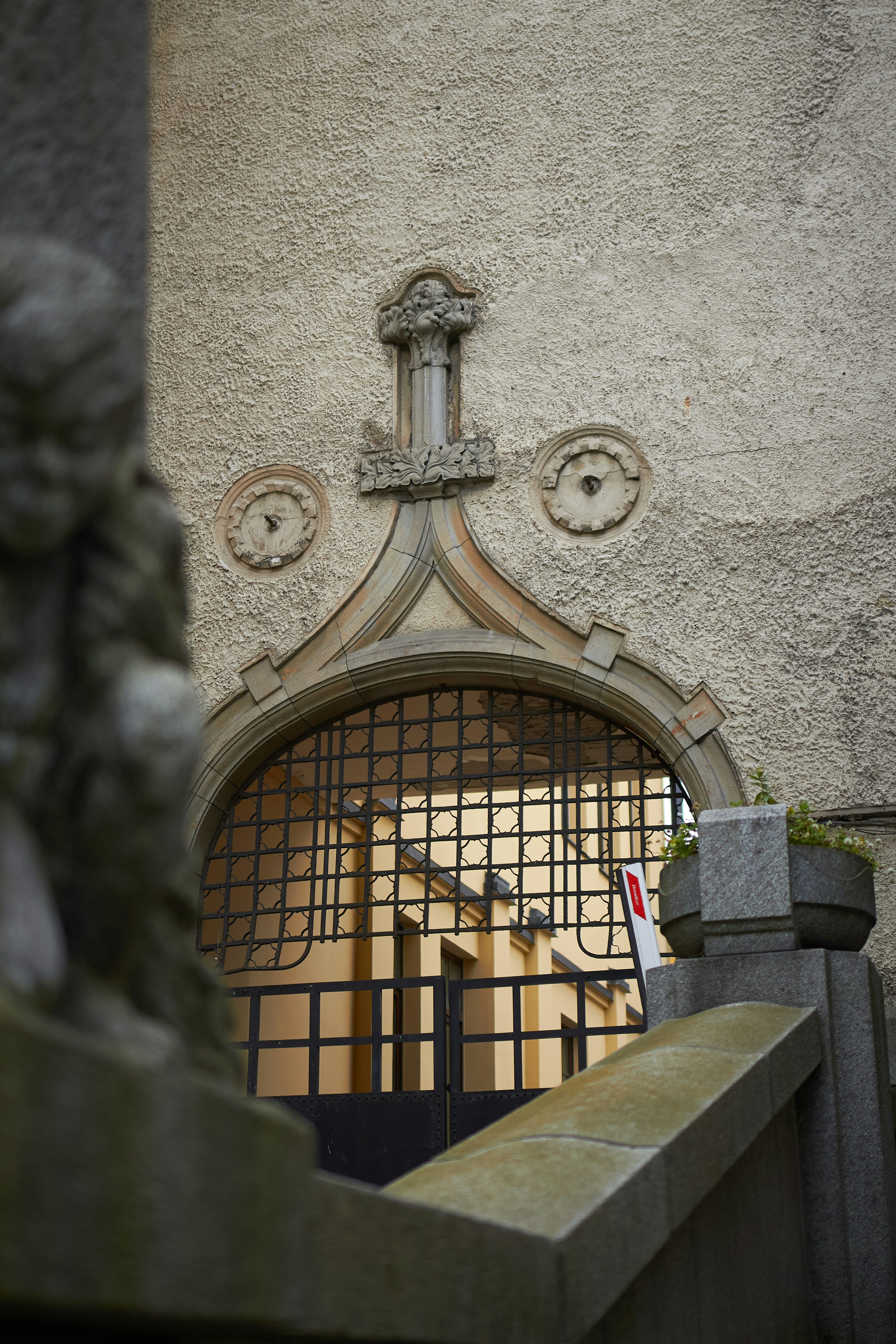 An ornate archway looks through iron gates.