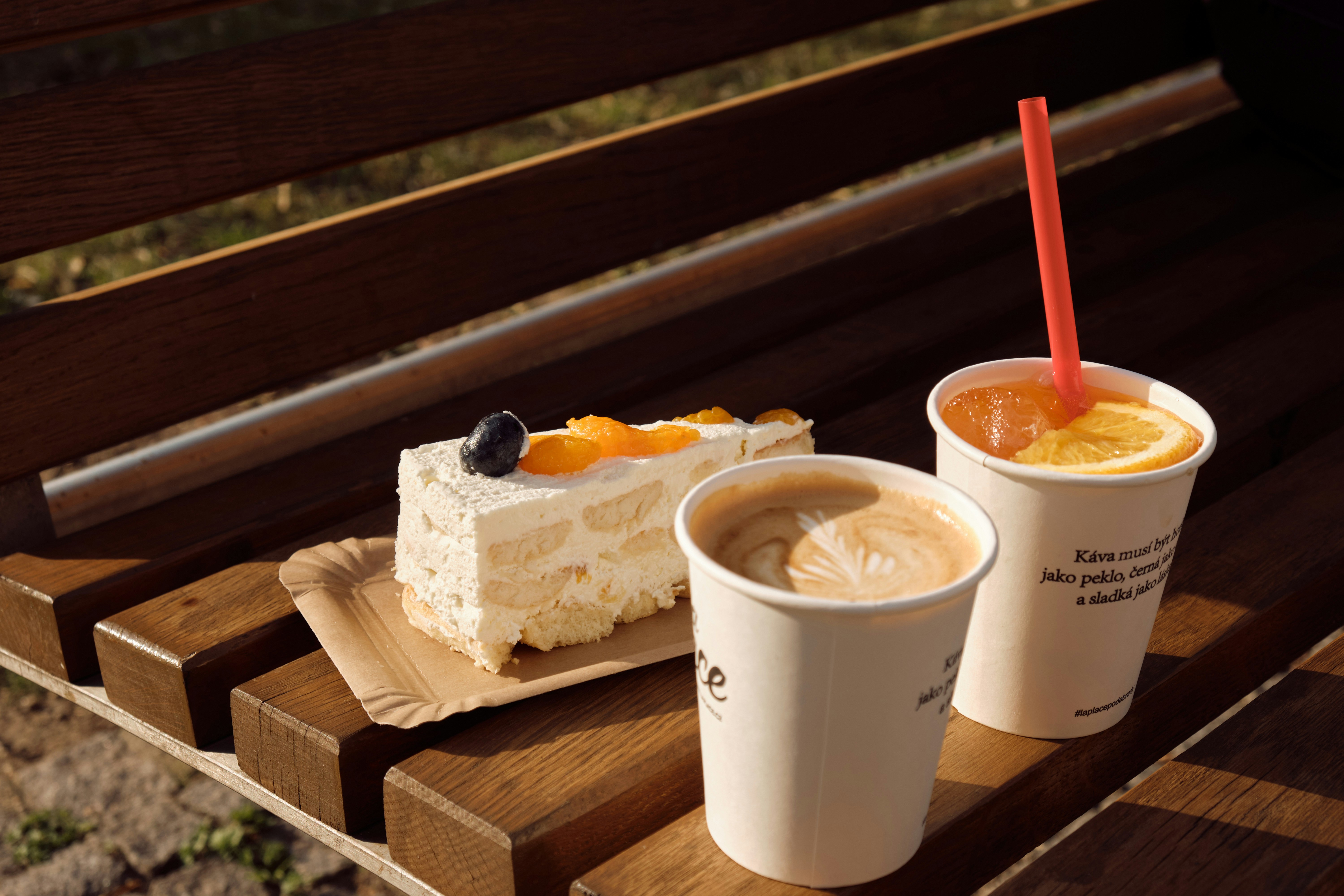 Relax, coffee, aperol and cake | Cake, coffee and juice on a wooden bench.