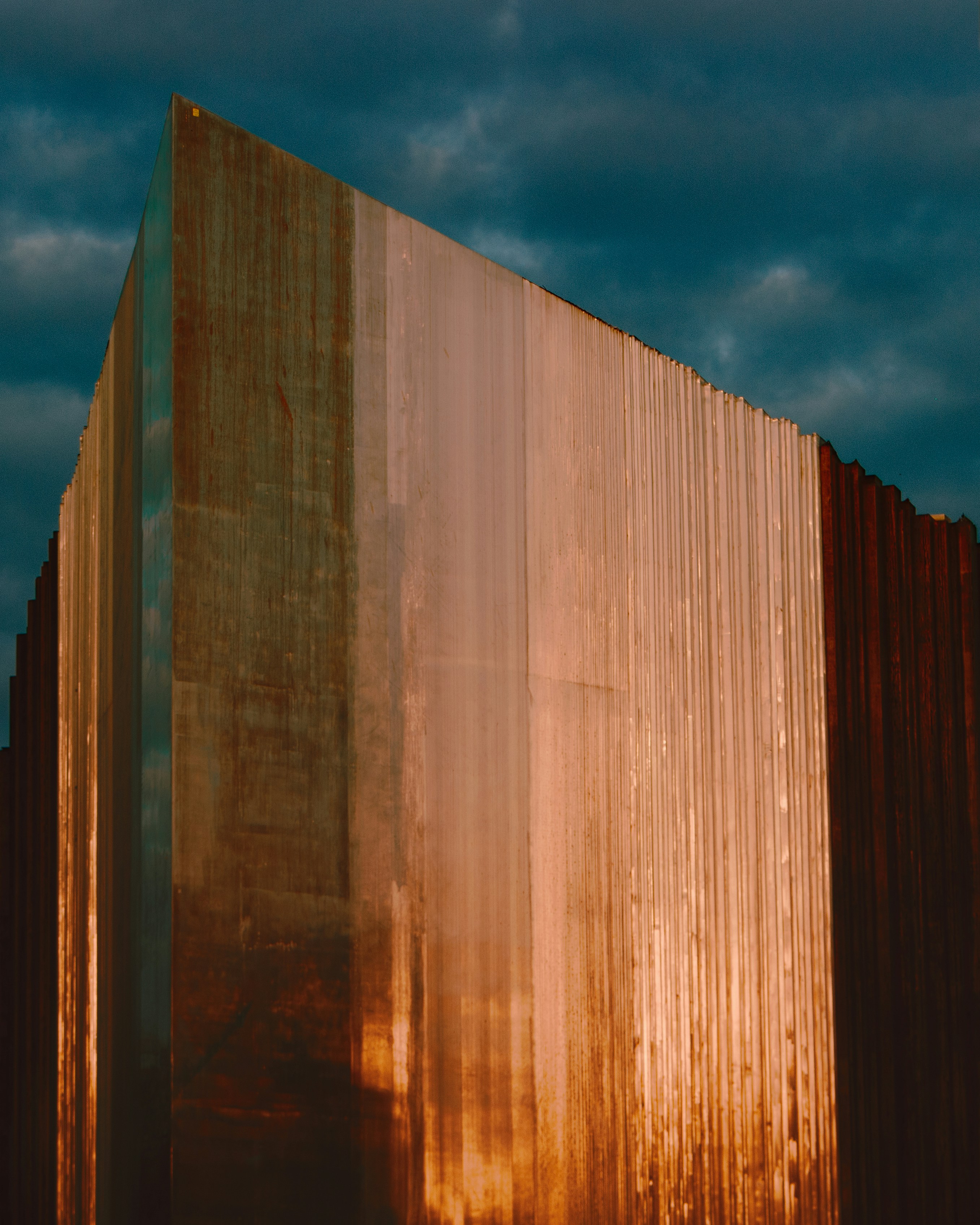 Copper building stands tall beneath a cloudy sky.