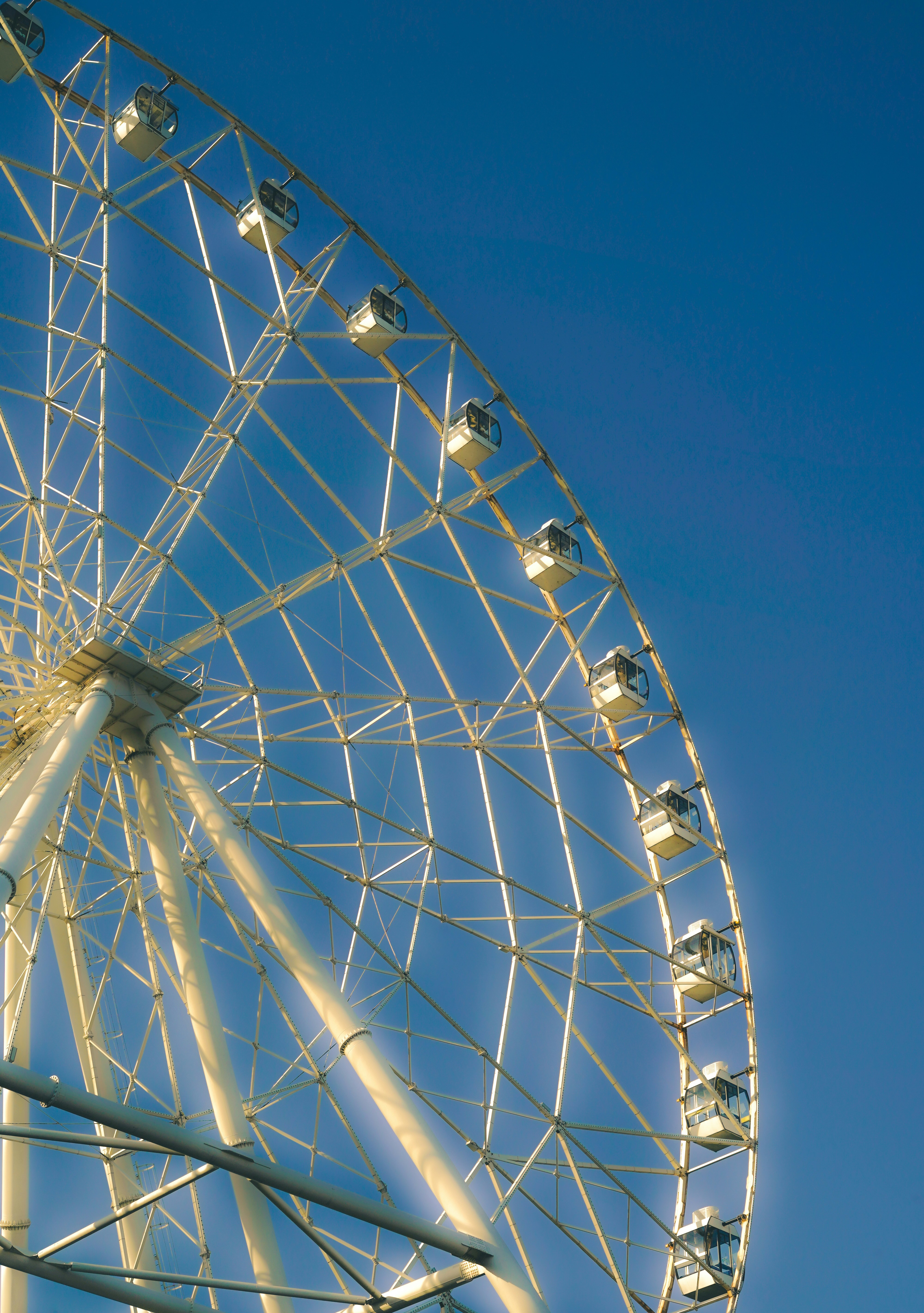 A ferris wheel against a bright blue sky.