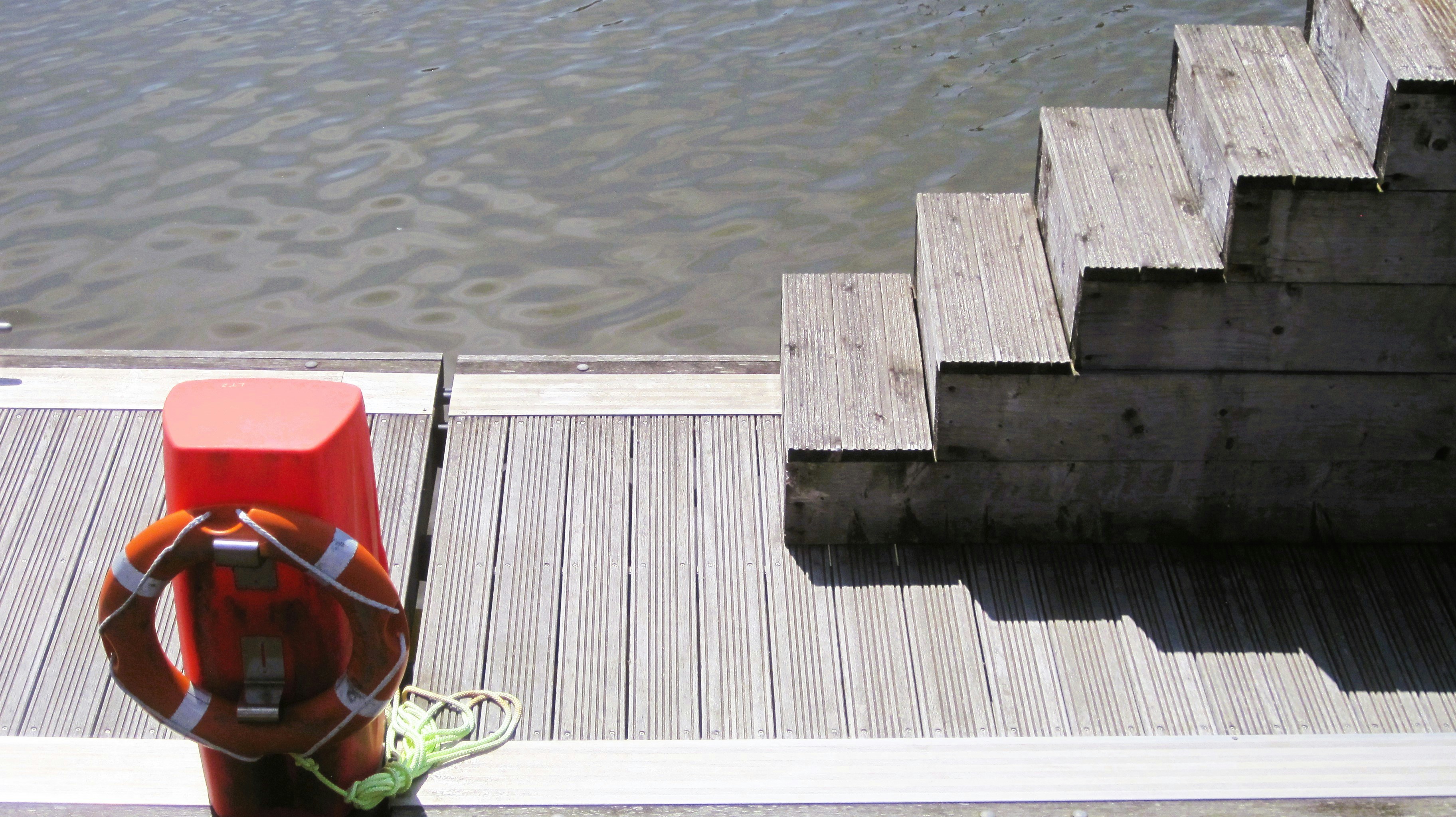 Life preserver and steps next to calm water. photo – Free Coast Image ...