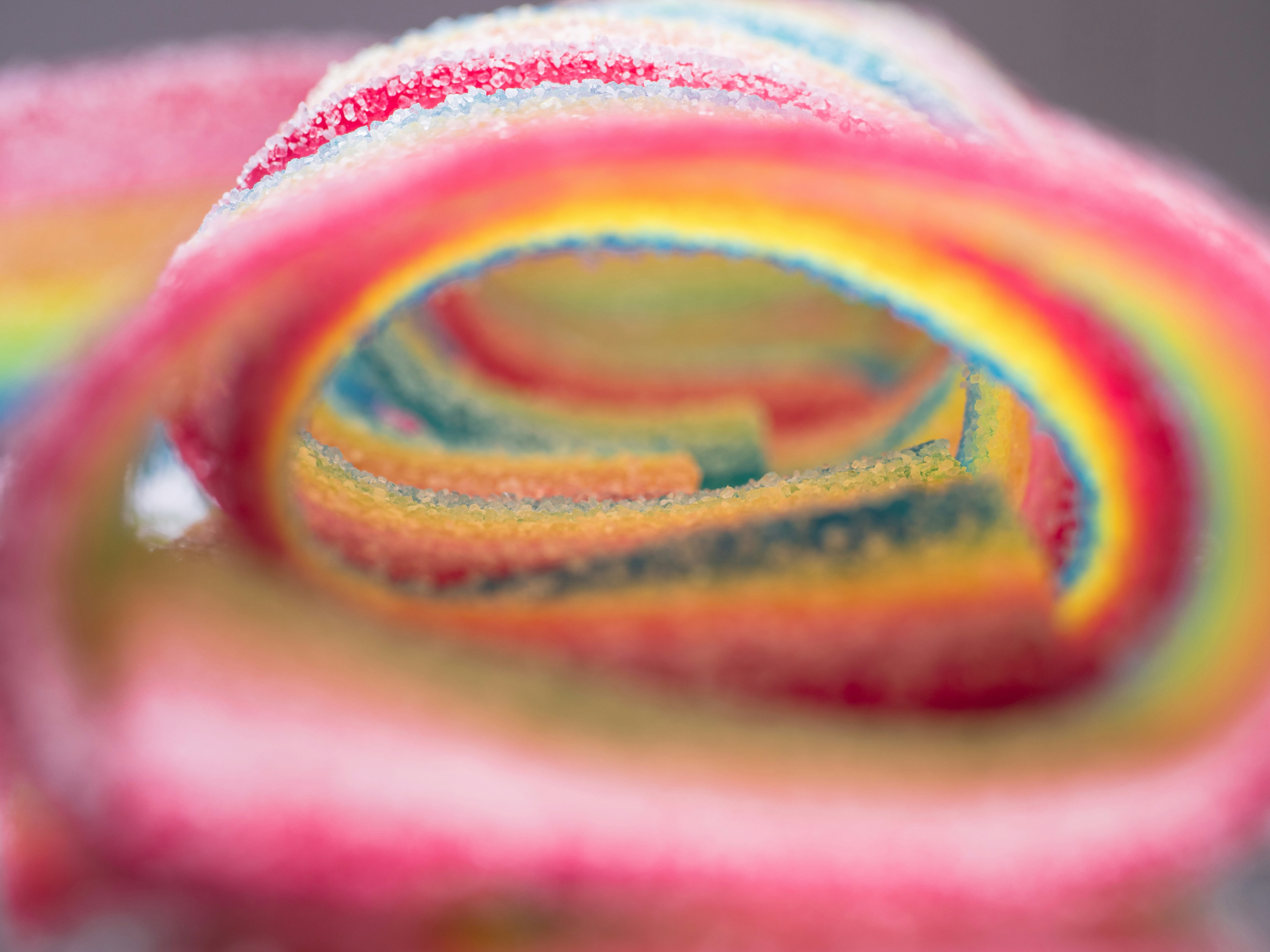 Rainbow candy is curled and dusted with sugar.