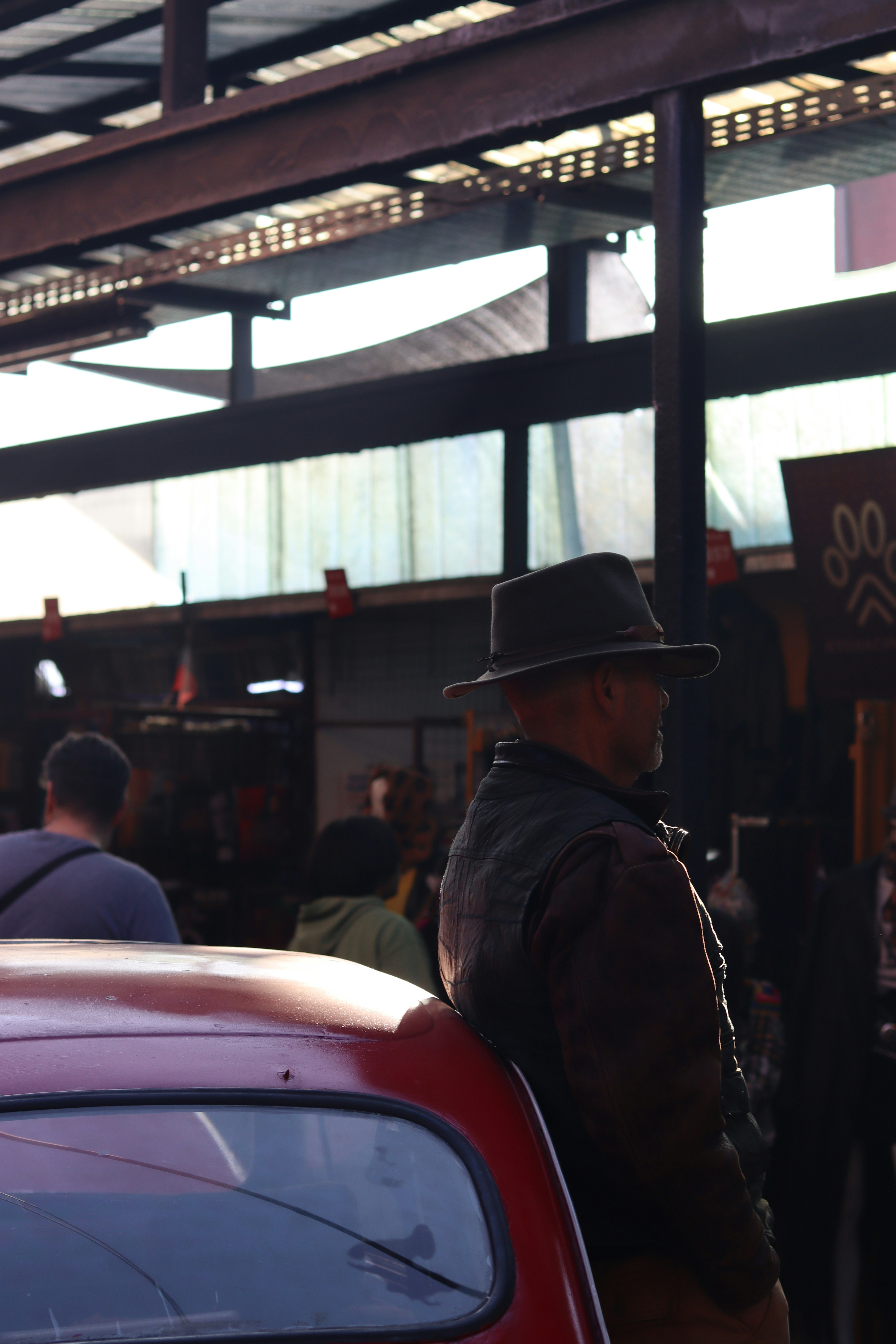 Shadowed Gentleman by the Market Car
