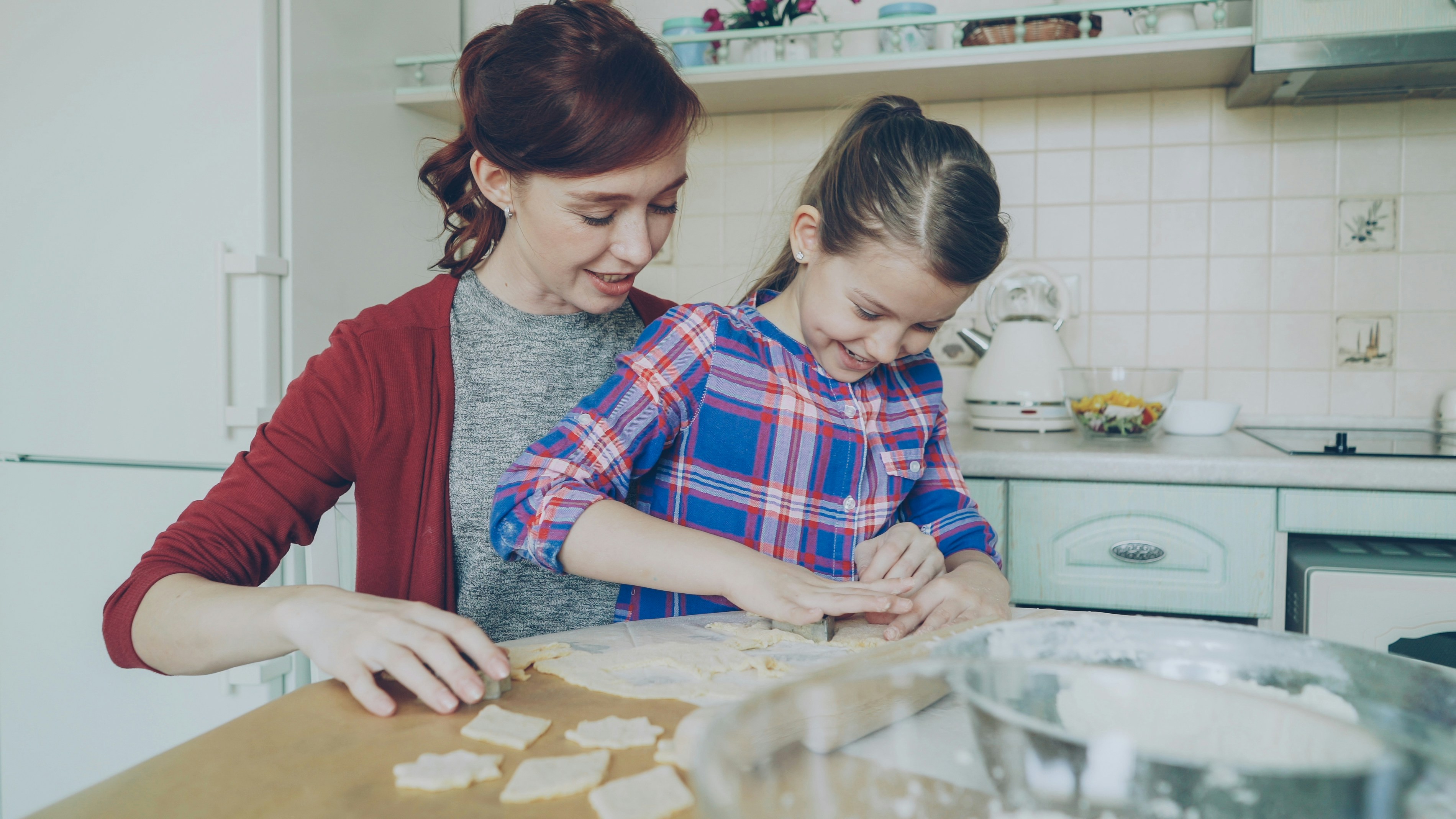 A mother and daughter bake cookies together in the kitchen. photo ...