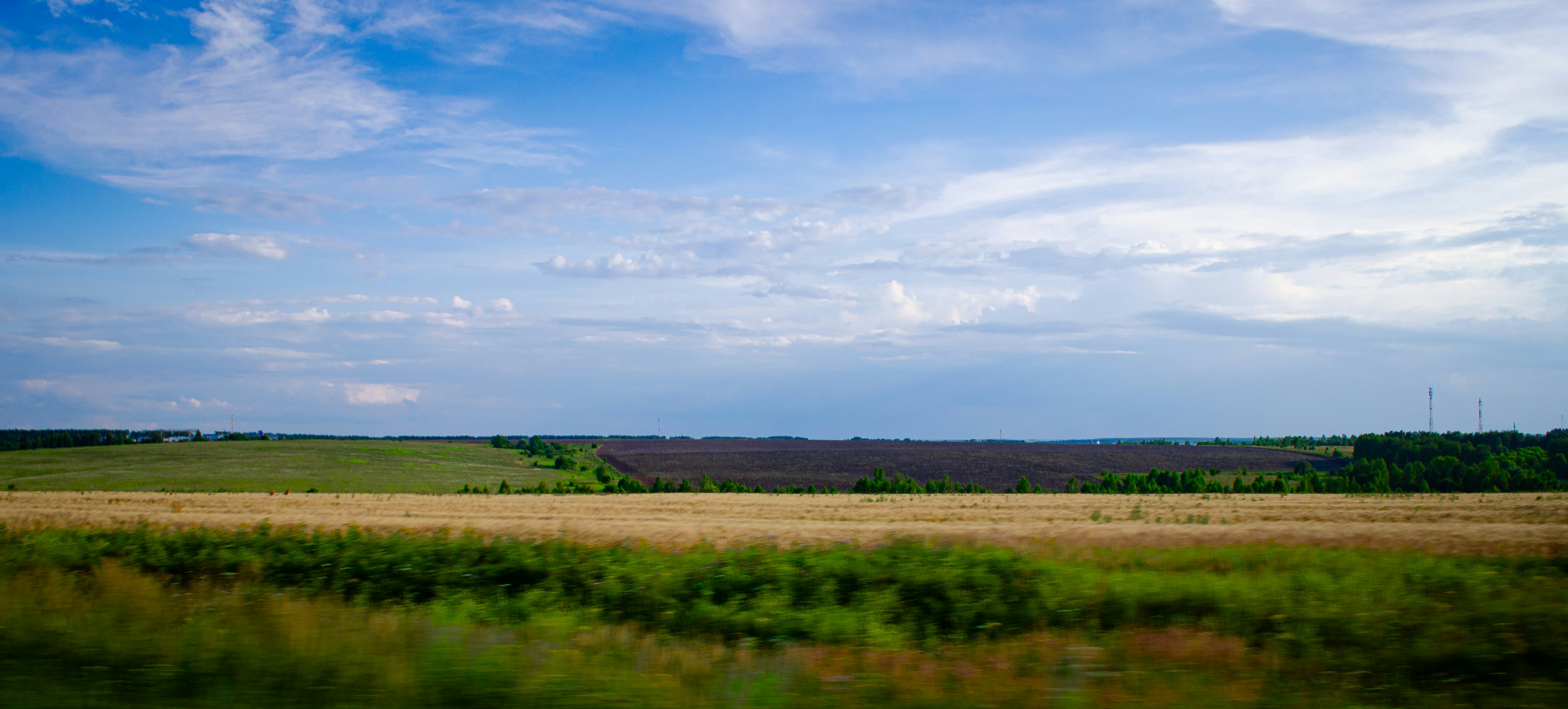 Fields under a cloudy sky.