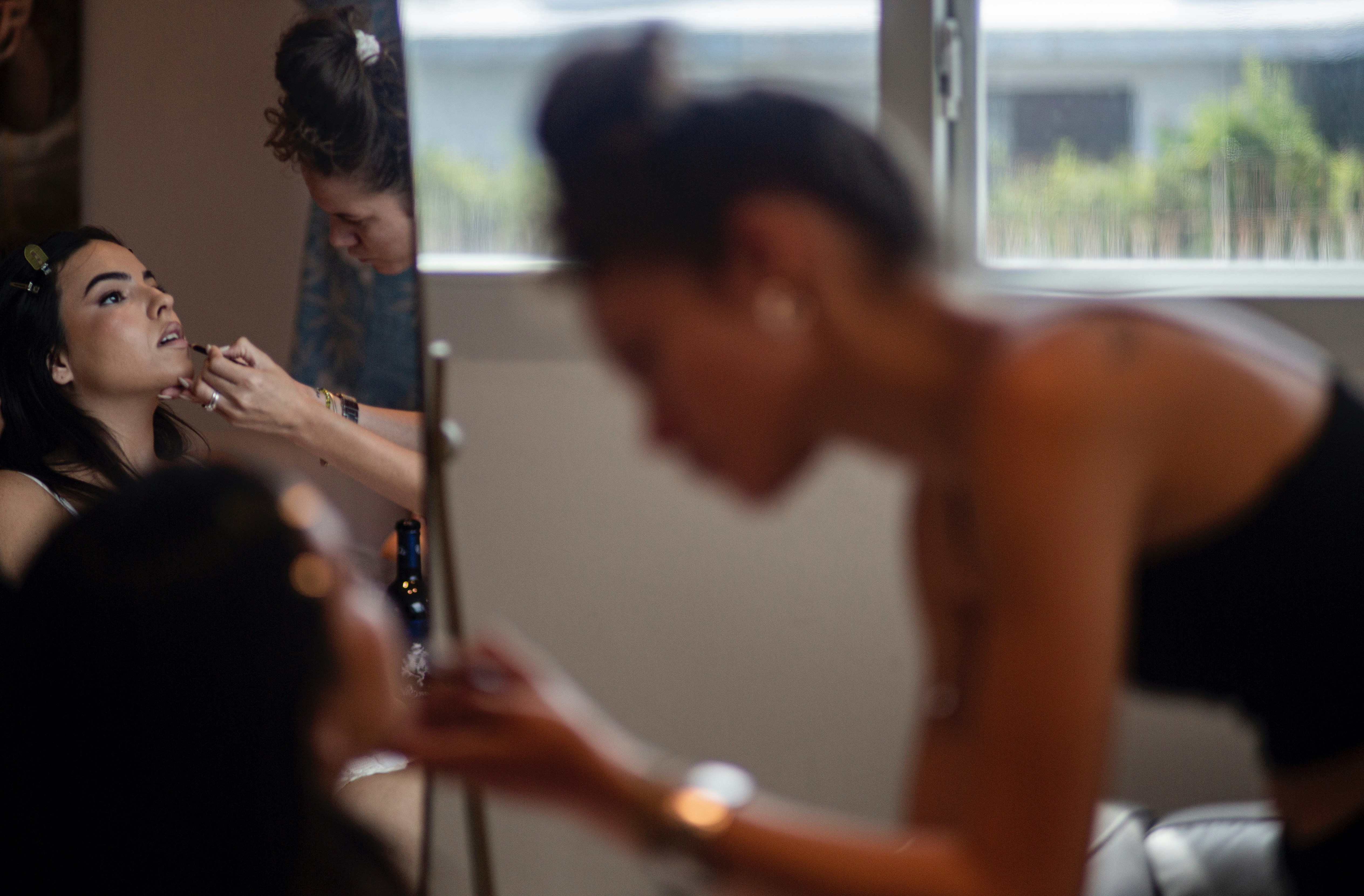 Work with style | A makeup artist is applying lipstick to a woman.