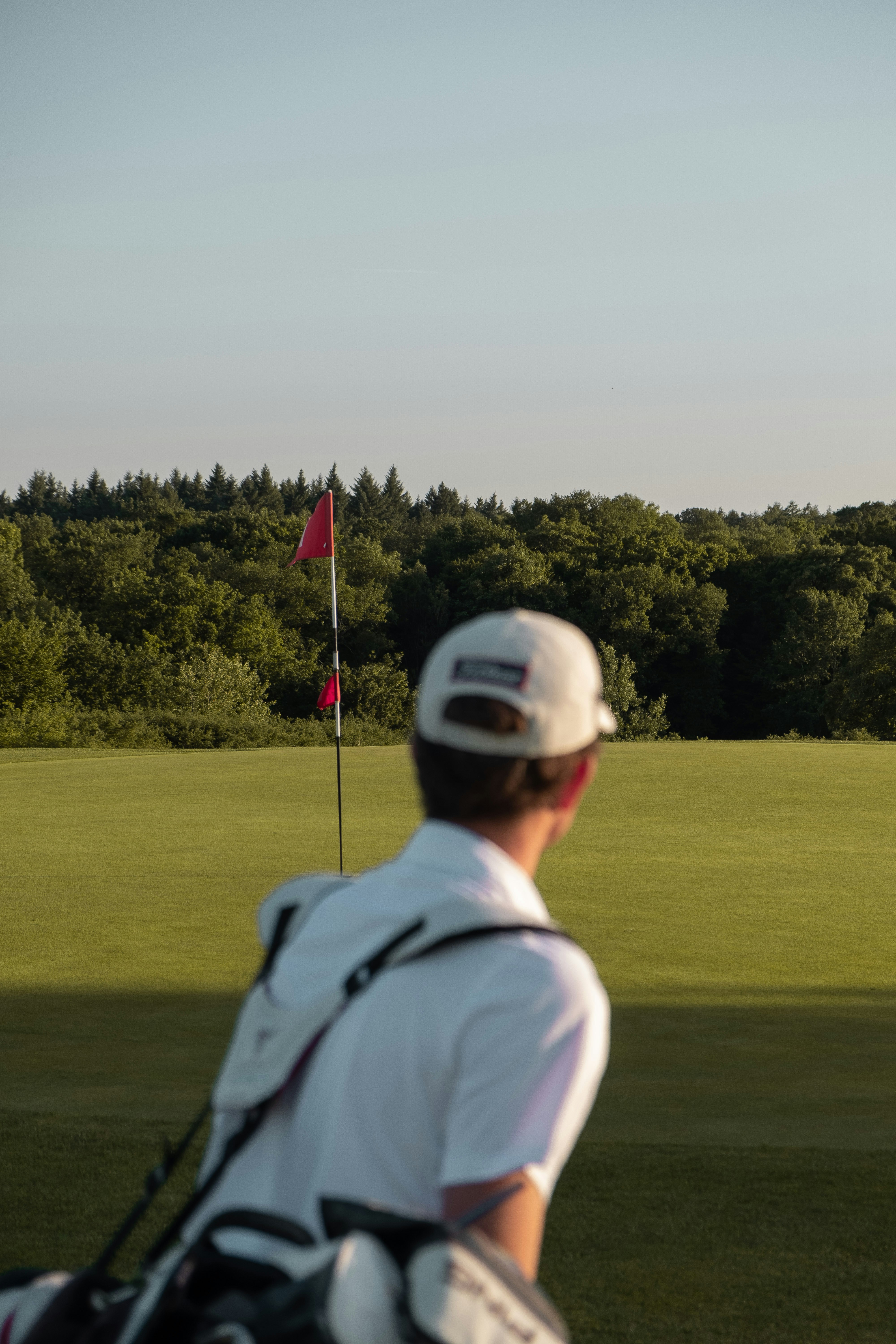 Front-Row Focus on the Golf Green: Foreground Player and Flag Marker