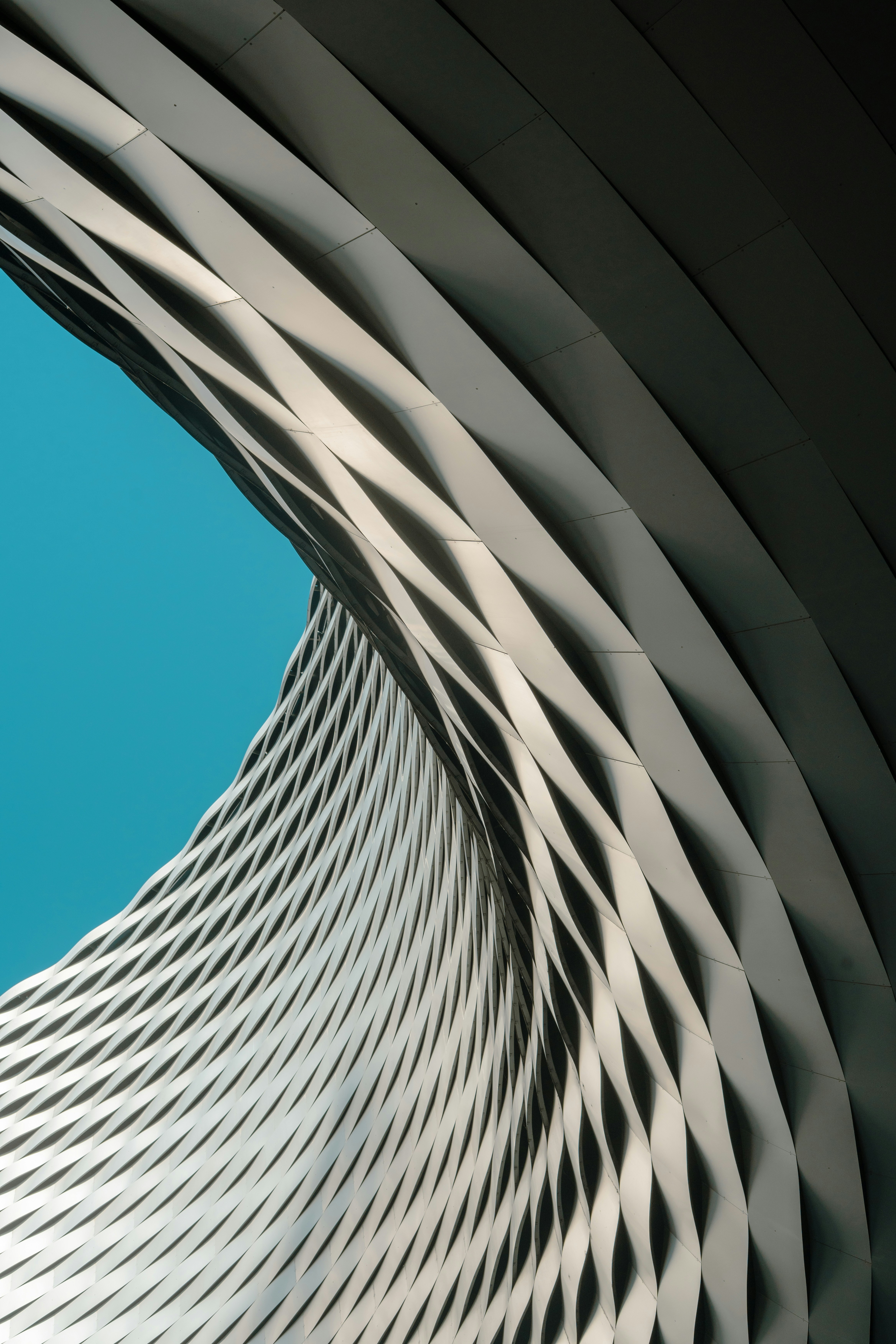 Architectural detail of a curved, patterned facade.