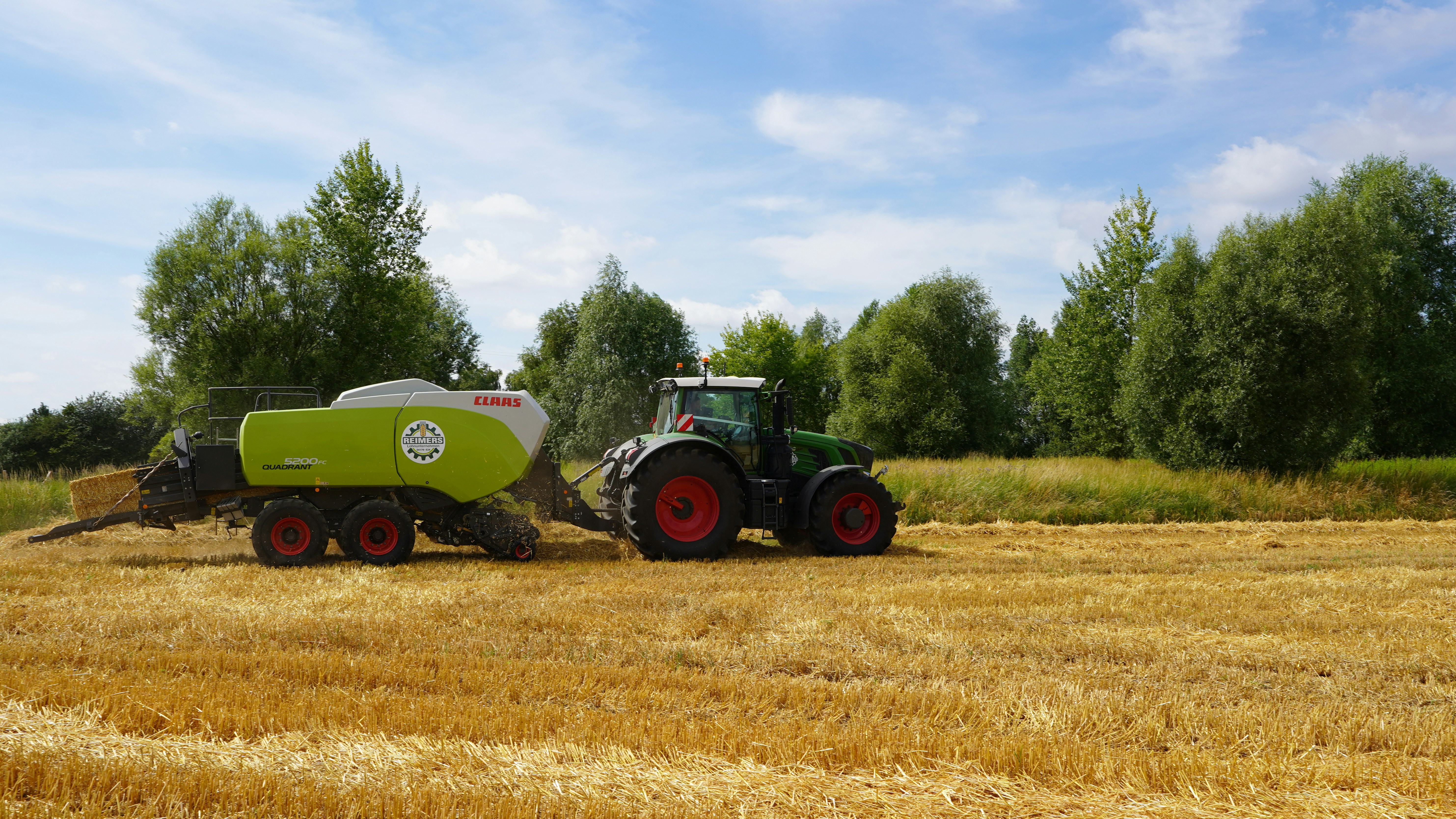 A tractor baler is working in a field.