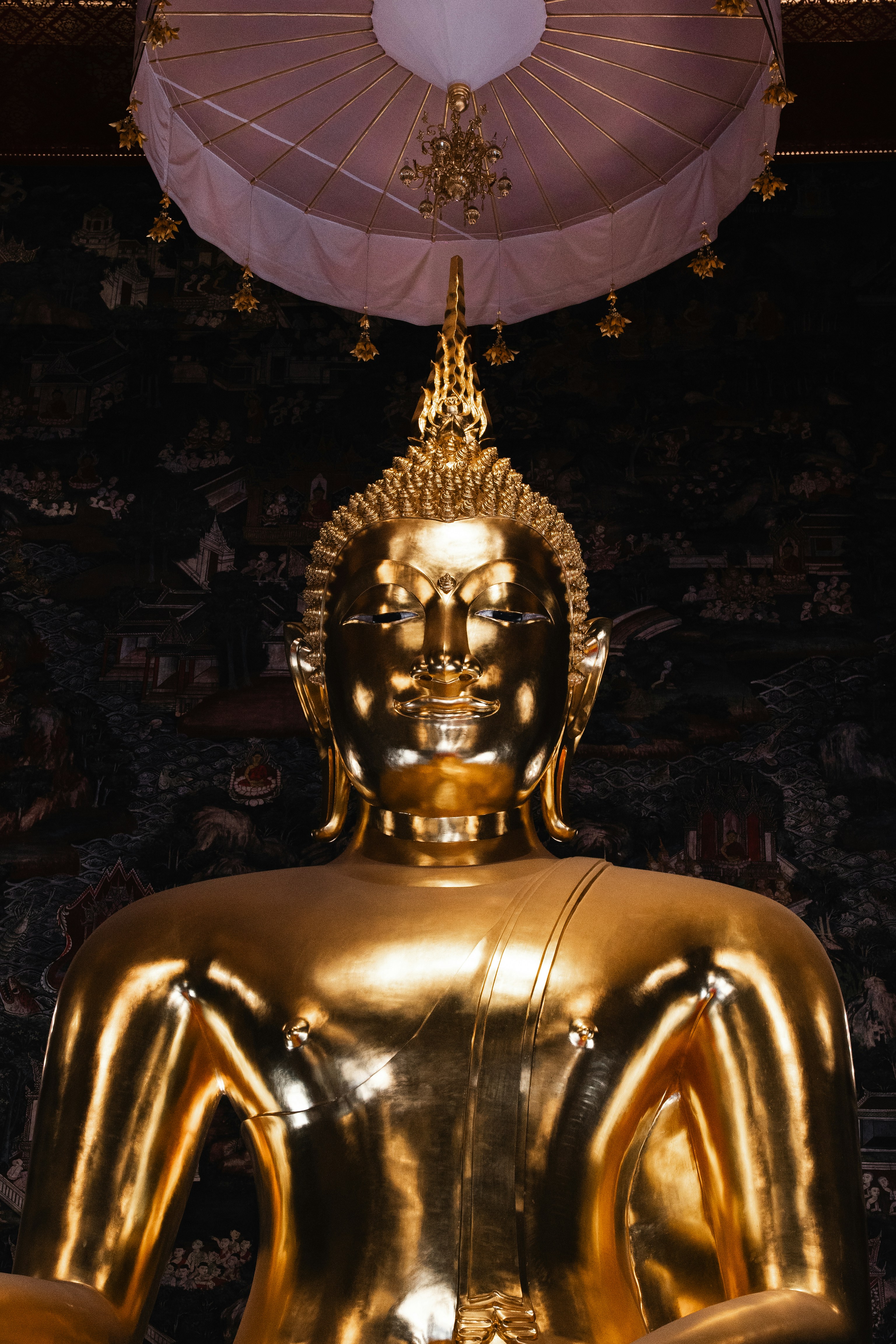 A golden buddha statue sits gracefully indoors.