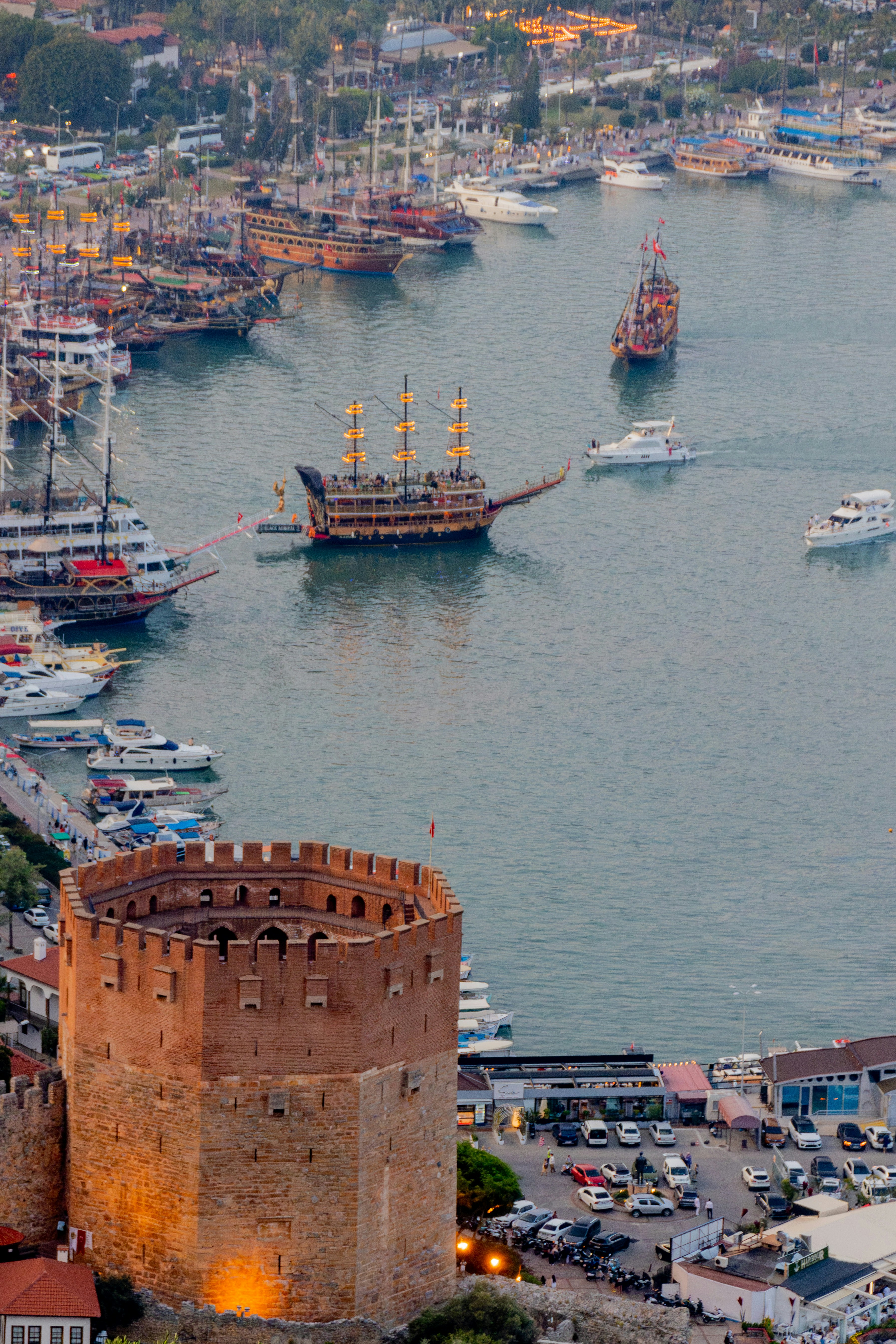 Alanya port | Boats and a castle overlook a busy harbor.