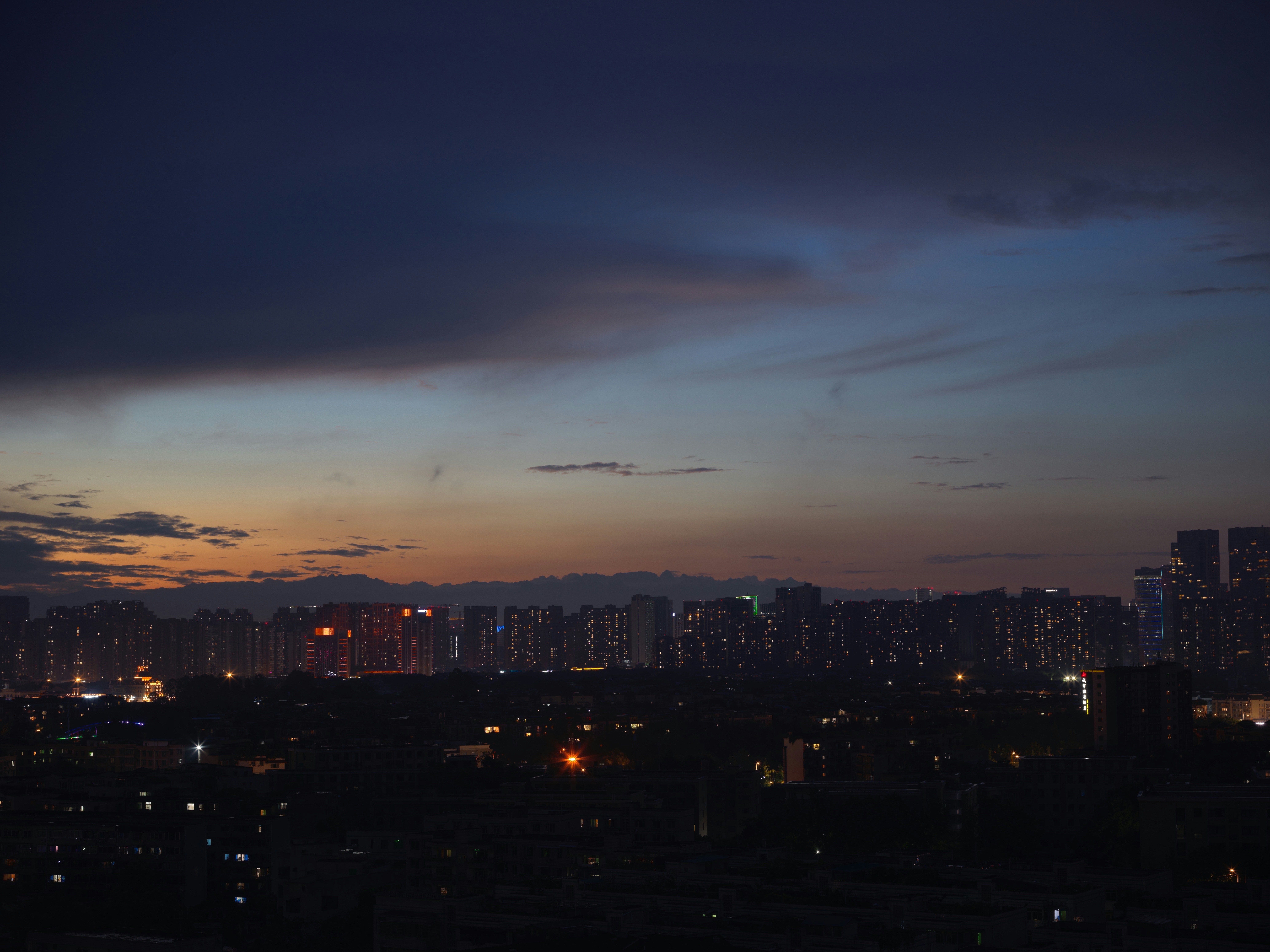 City skyline at dusk with dark clouds.