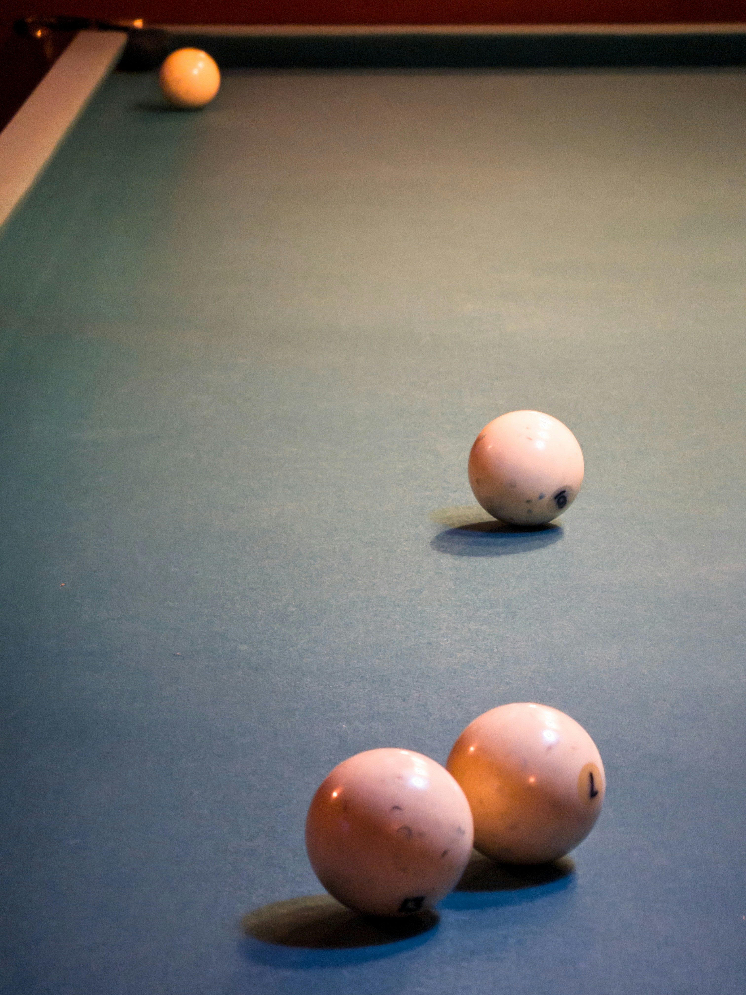 Blue Felt Pause: White Billiard Orbs Rest Under Warm Light