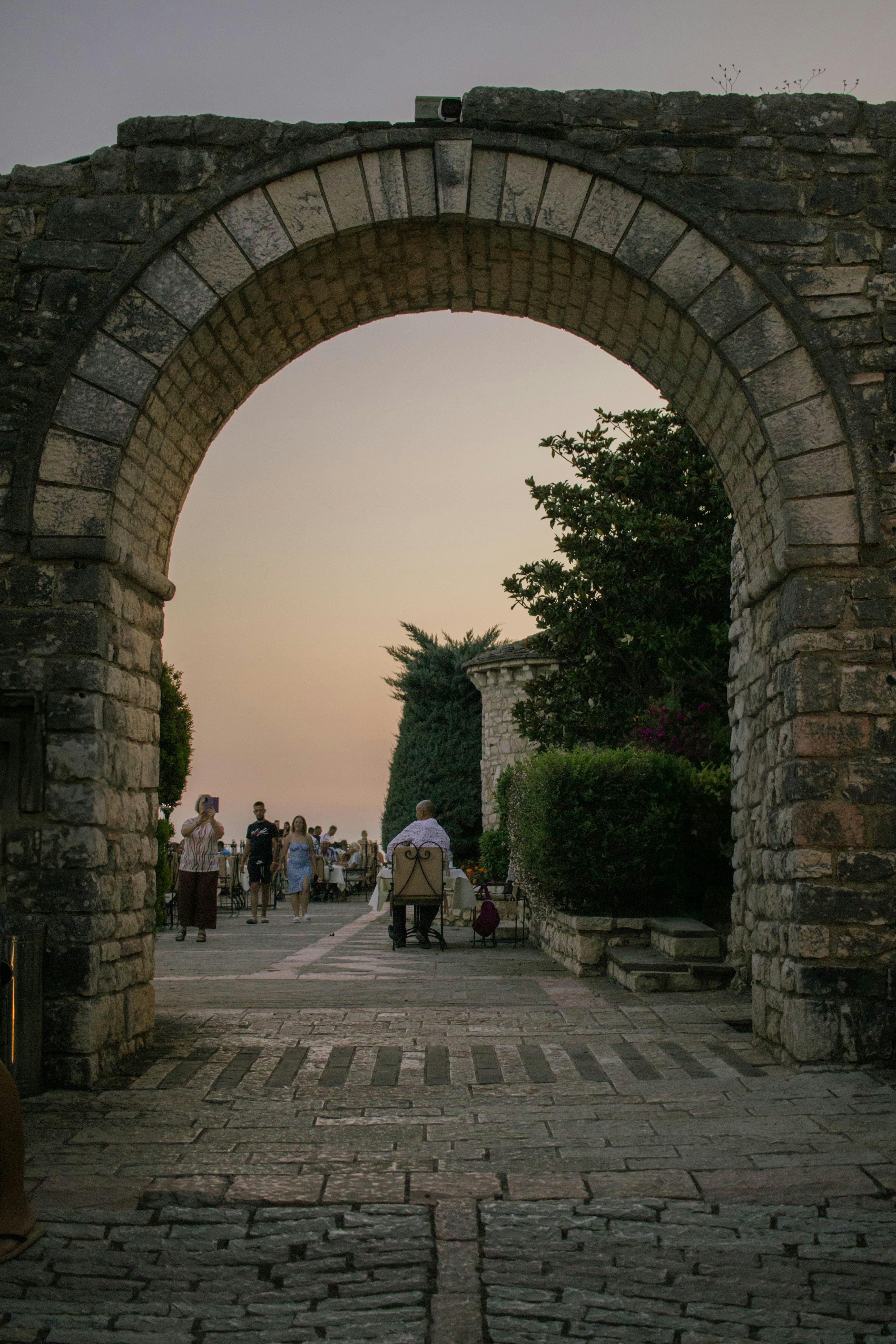 Ancient stone archway frames a scenic sunset.