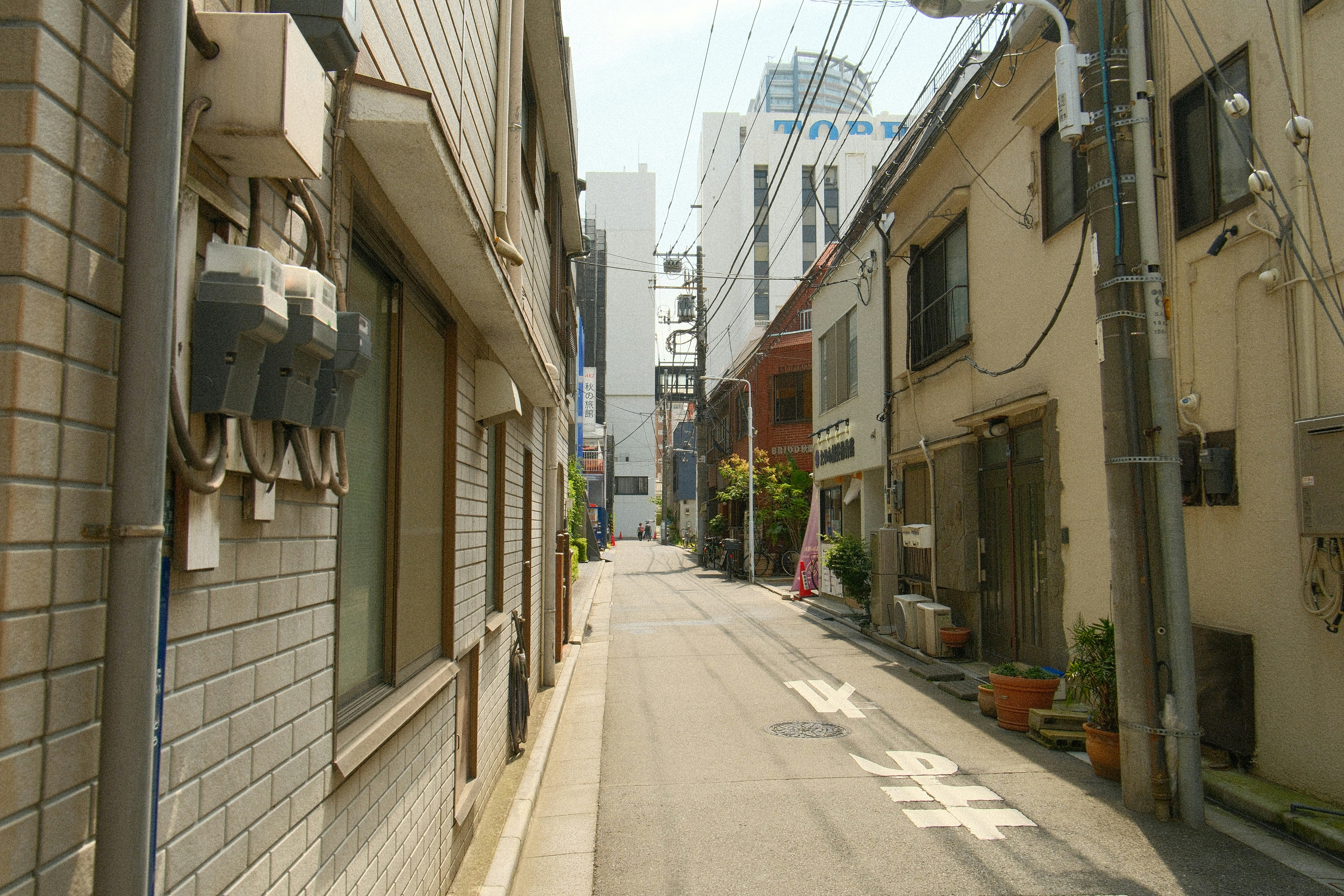 A narrow alleyway is framed by buildings.