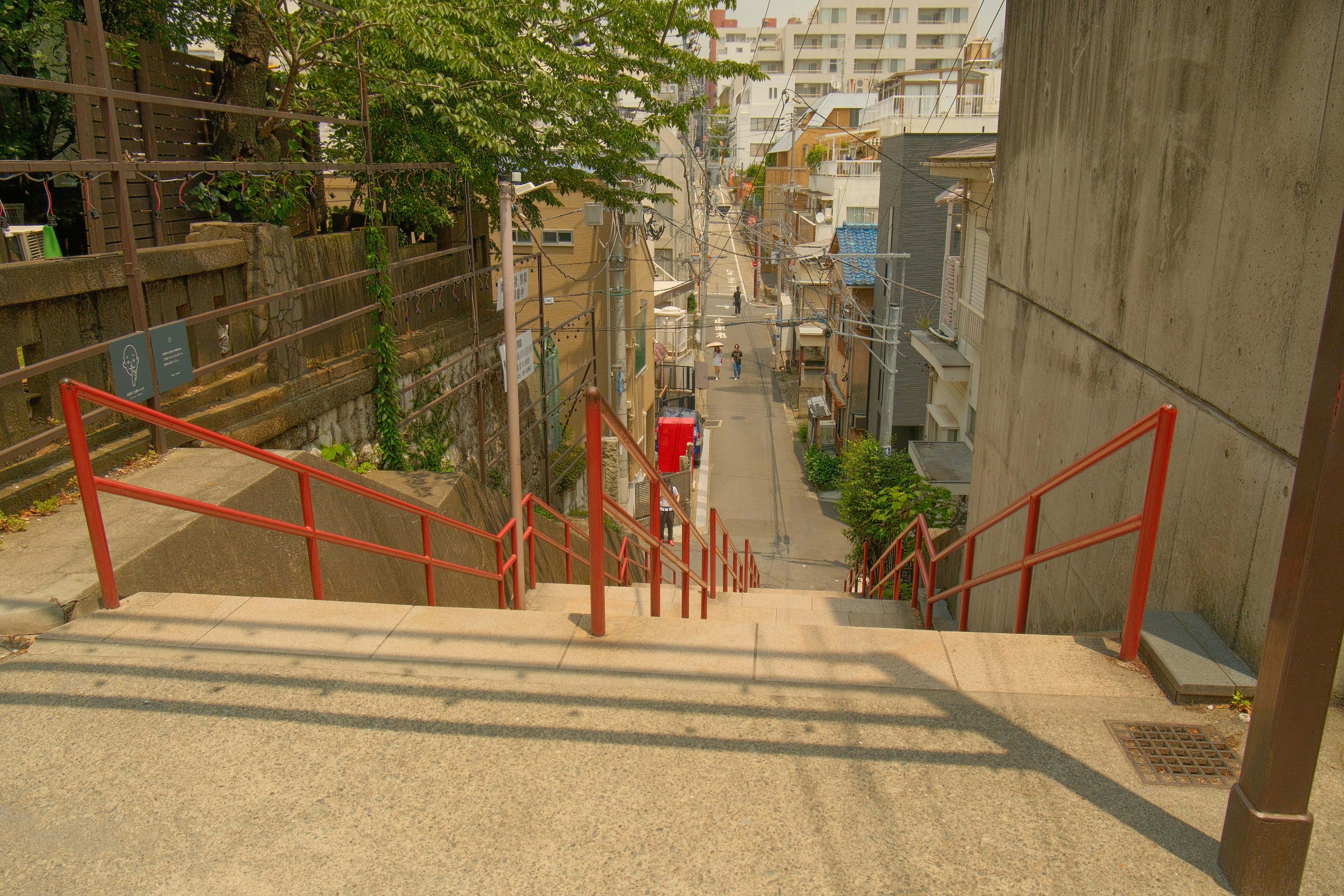 Steep stairs lead down to a bustling city street.