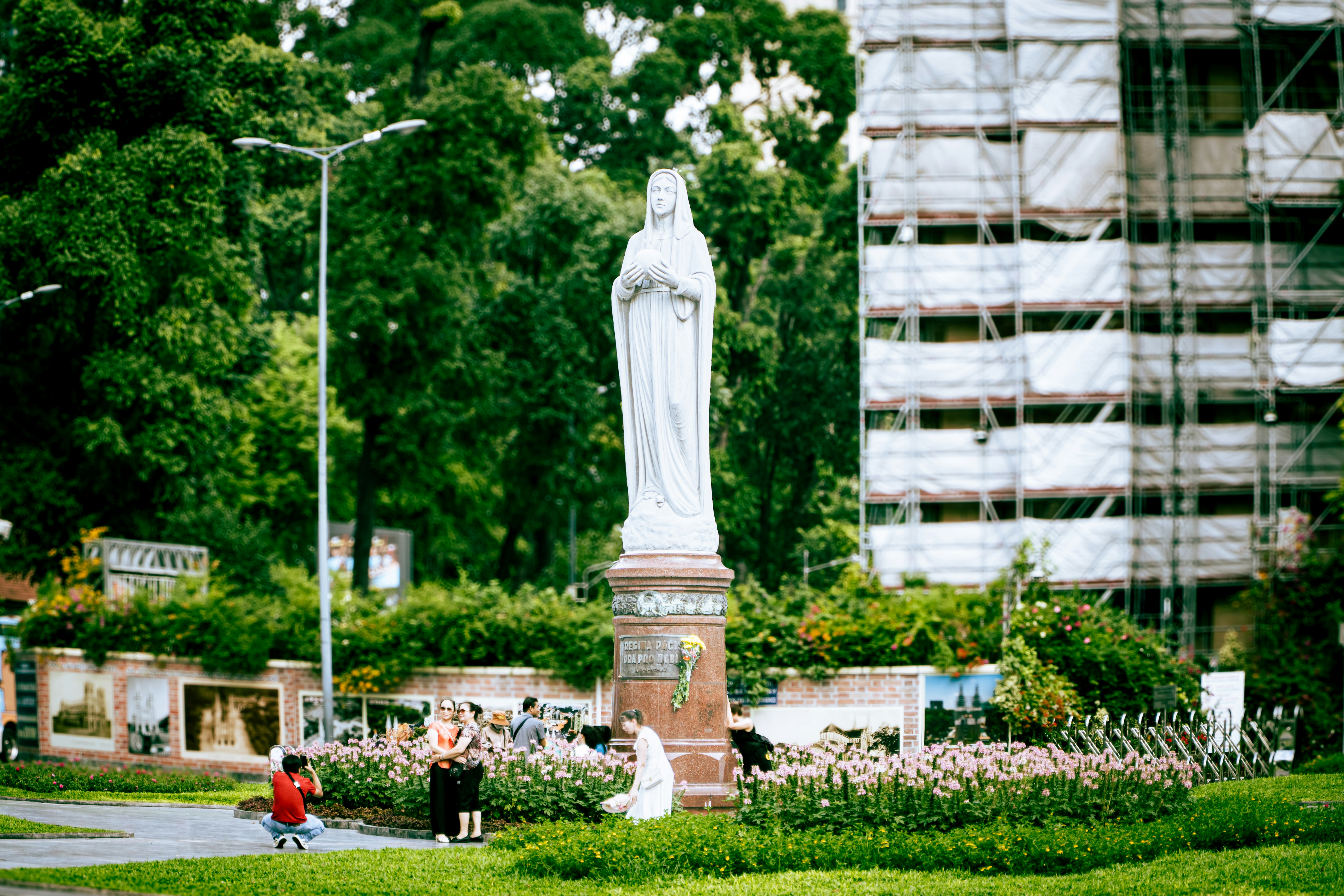 A statue of mary stands near a building.