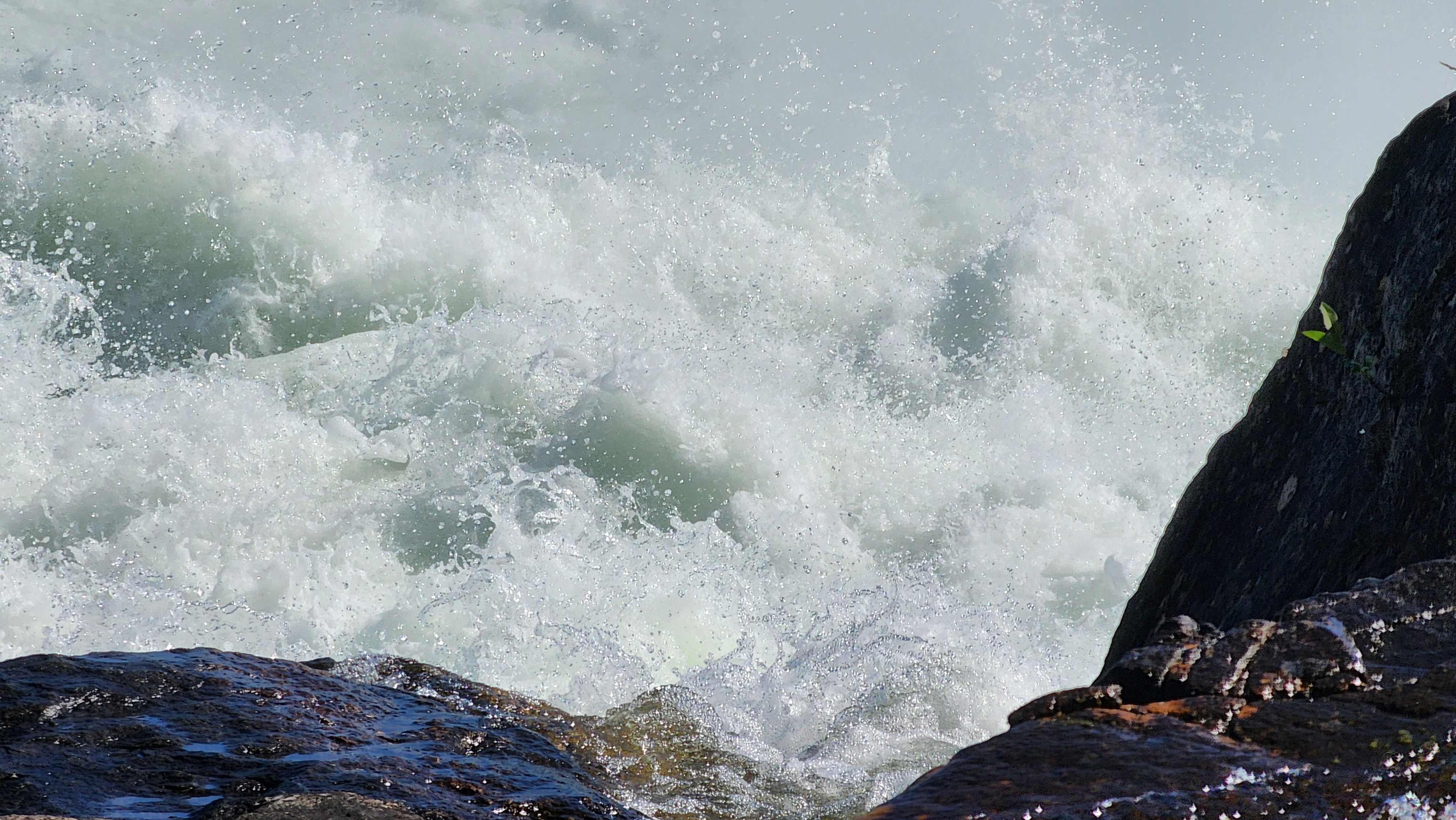 Les vagues s’écrasent contre les rochers, créant de l’eau blanche ...