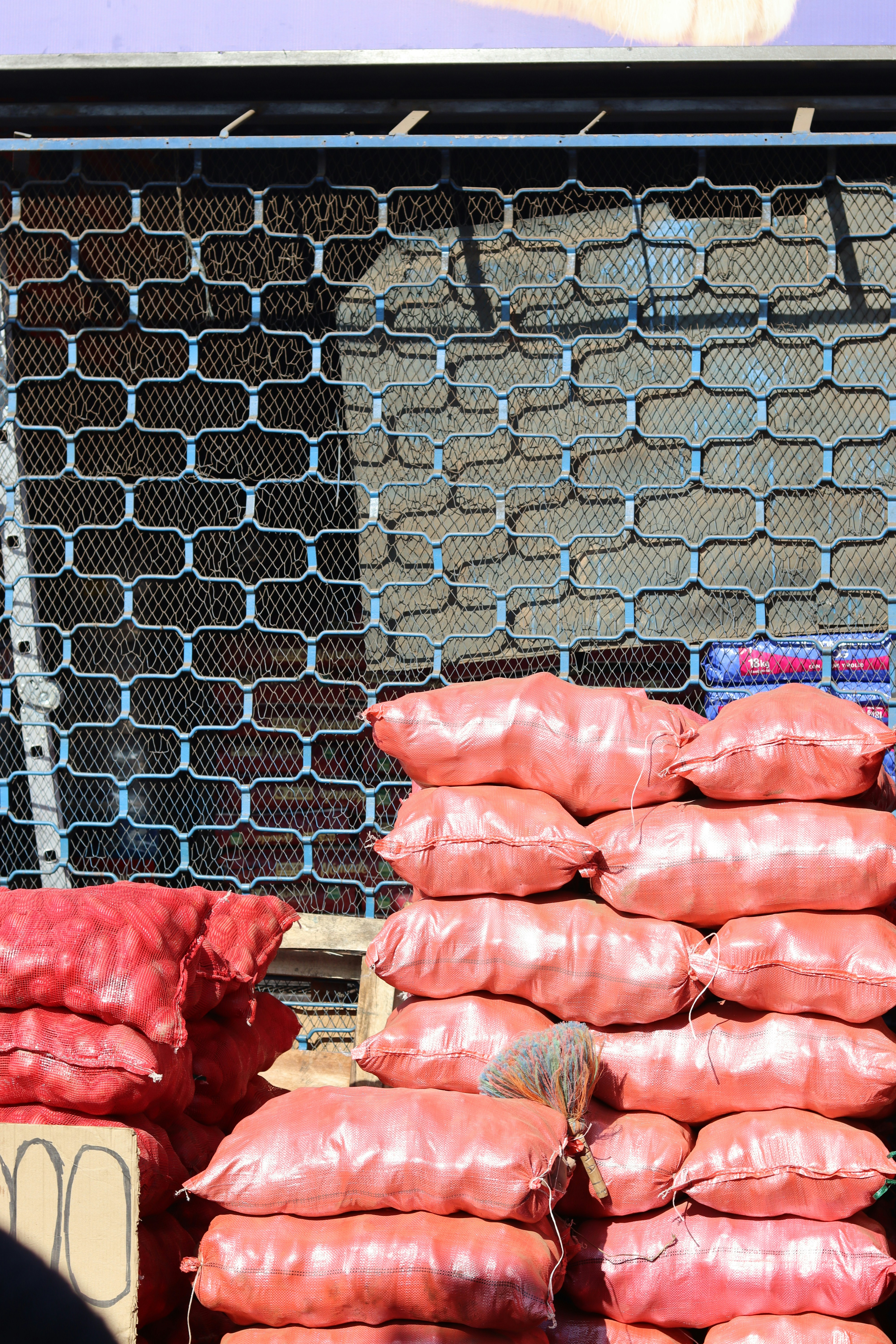 Red Sandbags and Industrial Mesh: Quiet Dusk Behind the Gate