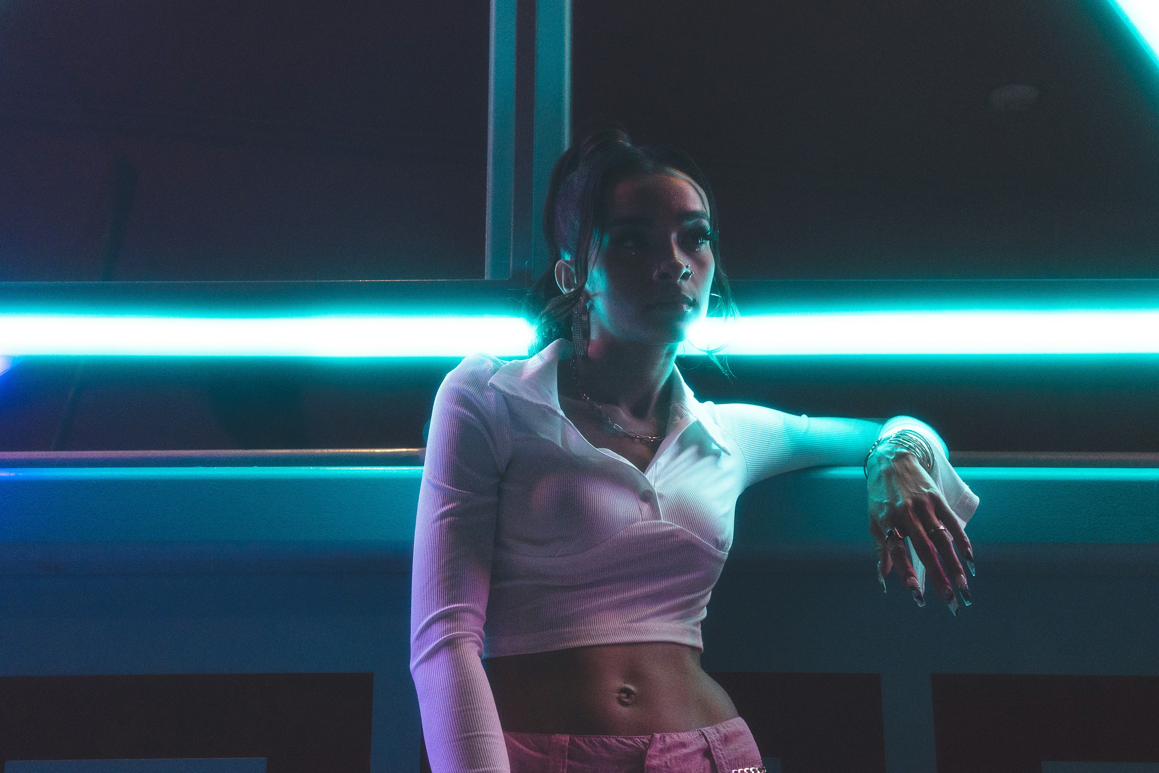 A woman poses with neon lighting.